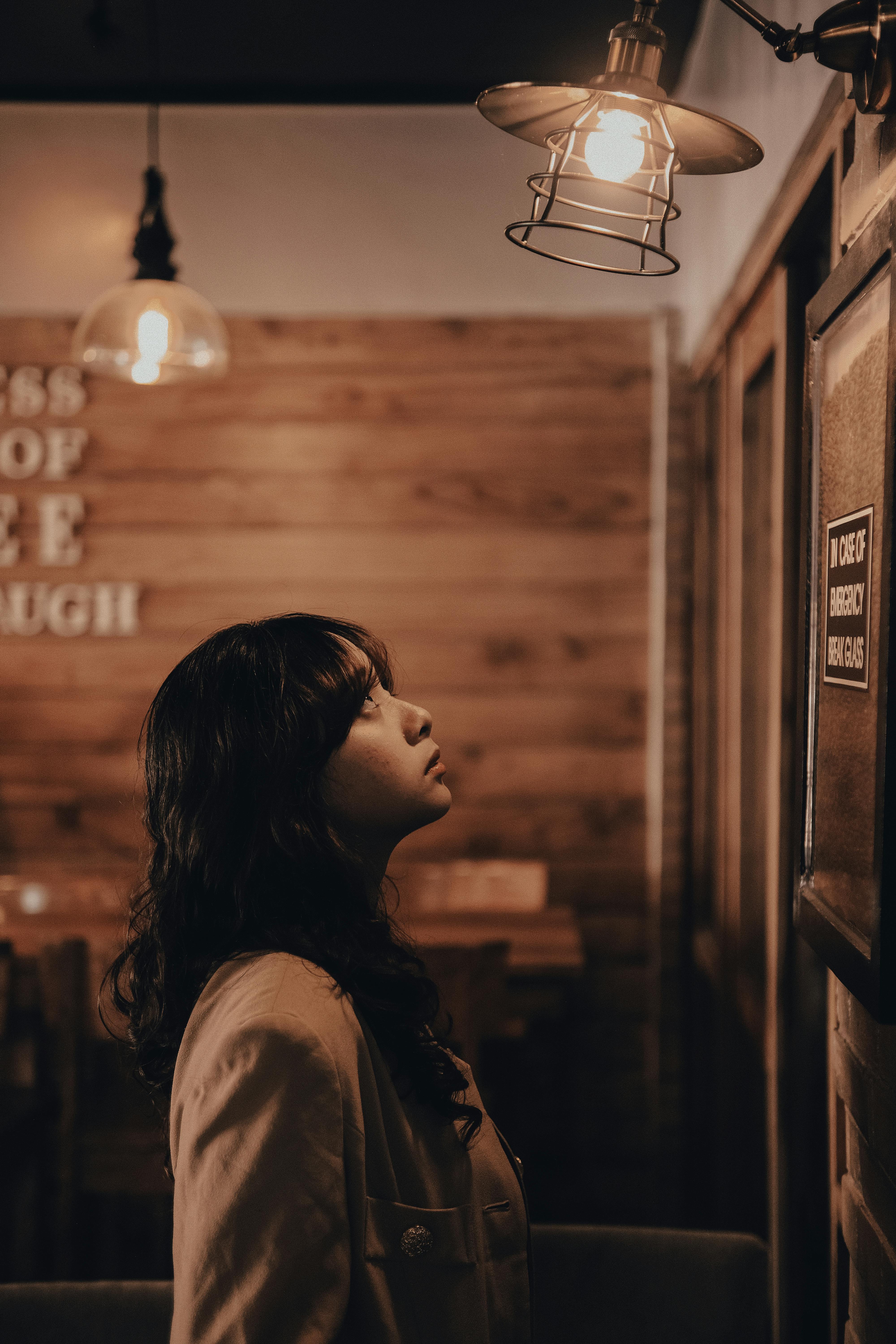 Side View of a Young Woman Standing in front of a Wall in a Cafe · Free ...