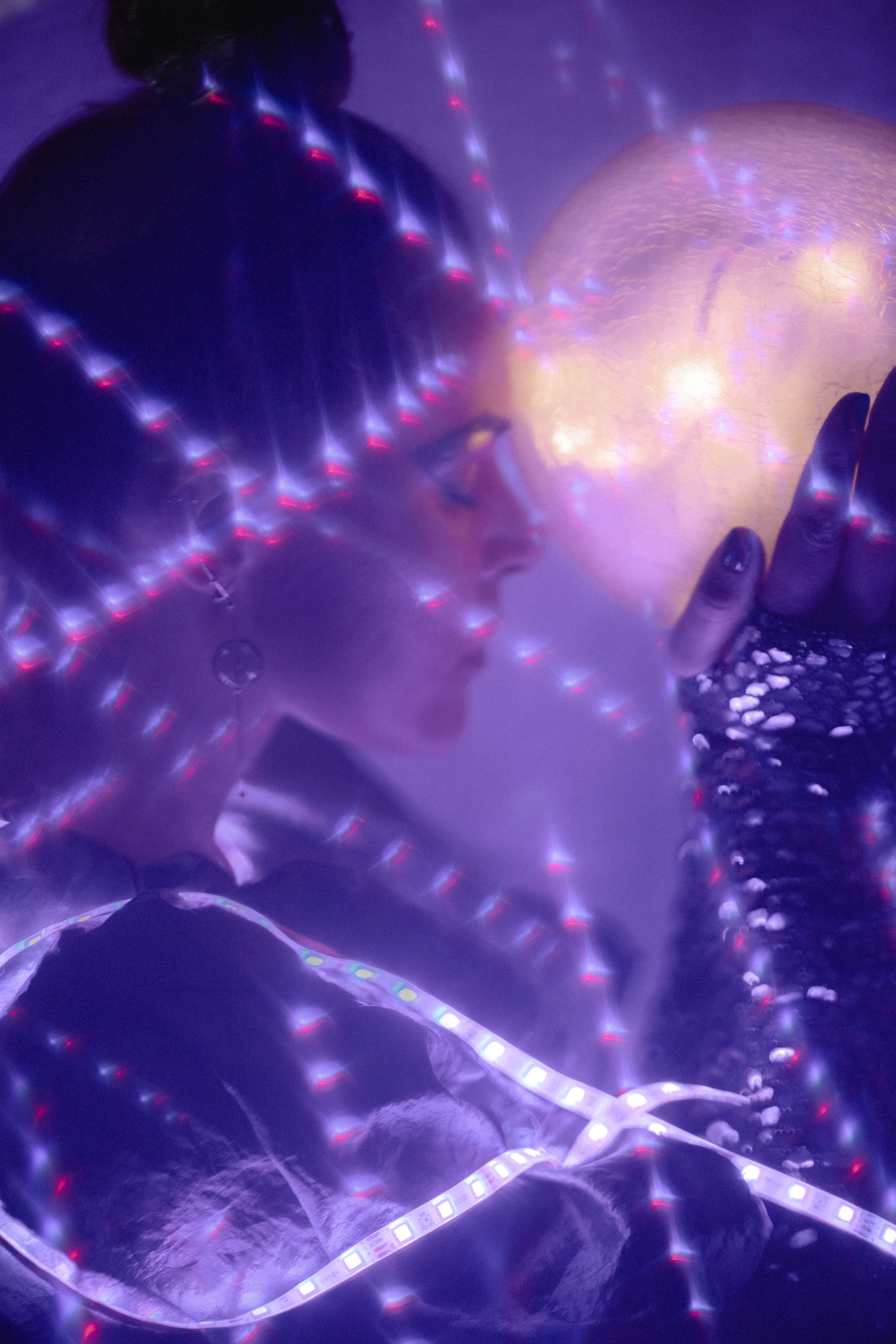 Photo of a Woman Holding a Shiny Purple LED Light String · Free Stock Photo