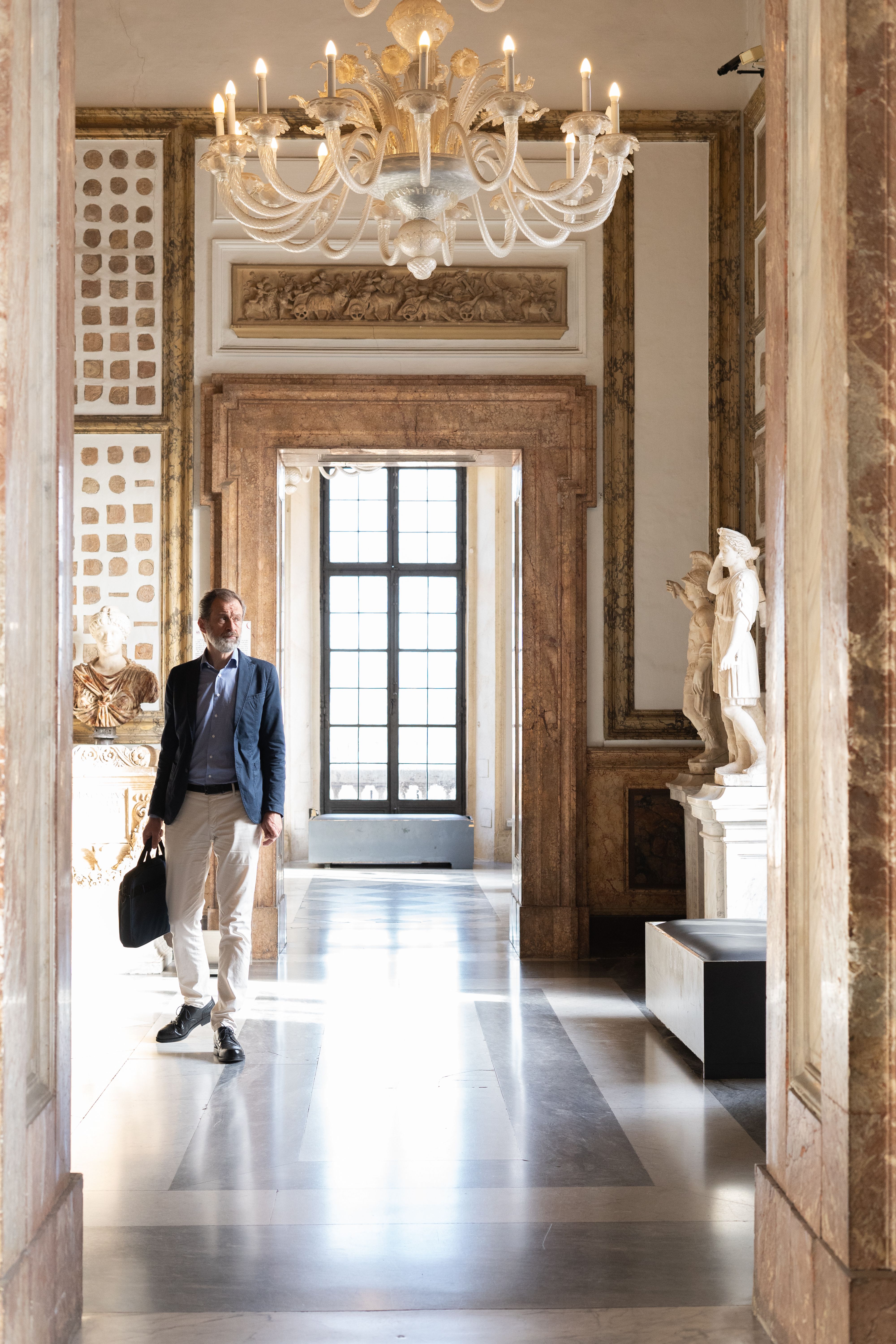 A man in a suit walking through a hallway · Free Stock Photo
