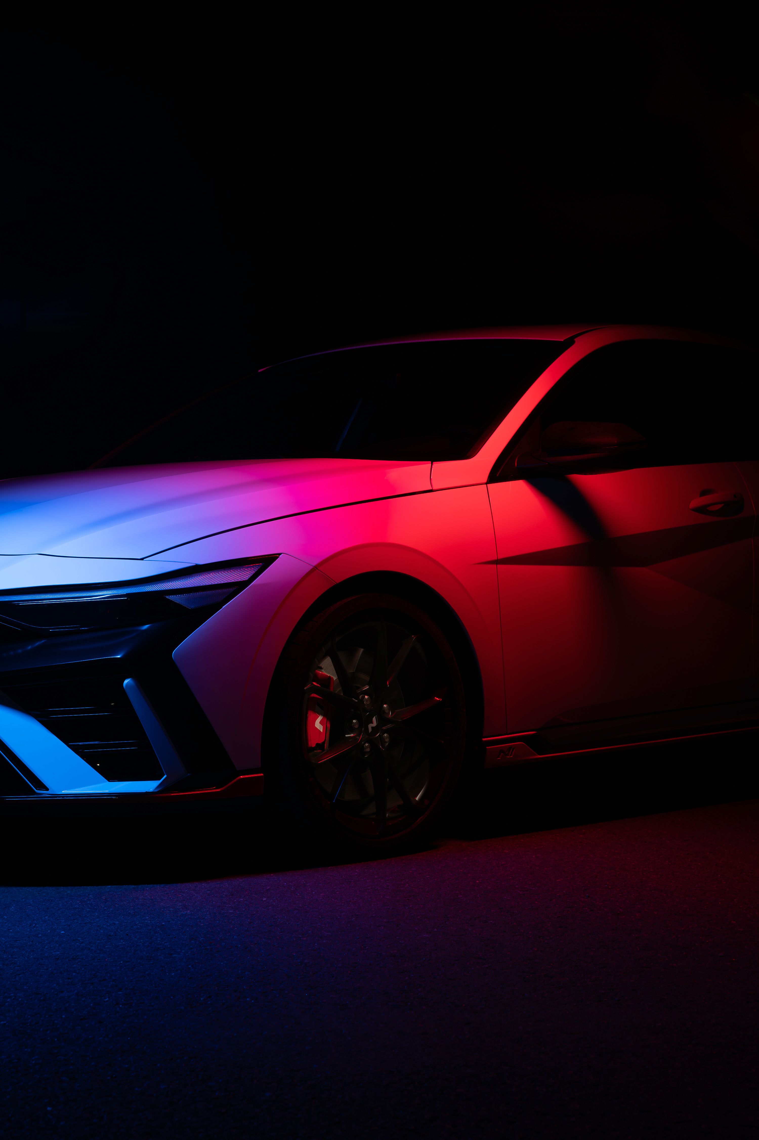 The left side view of the Hyundai Elantra N underneath studio lights ...