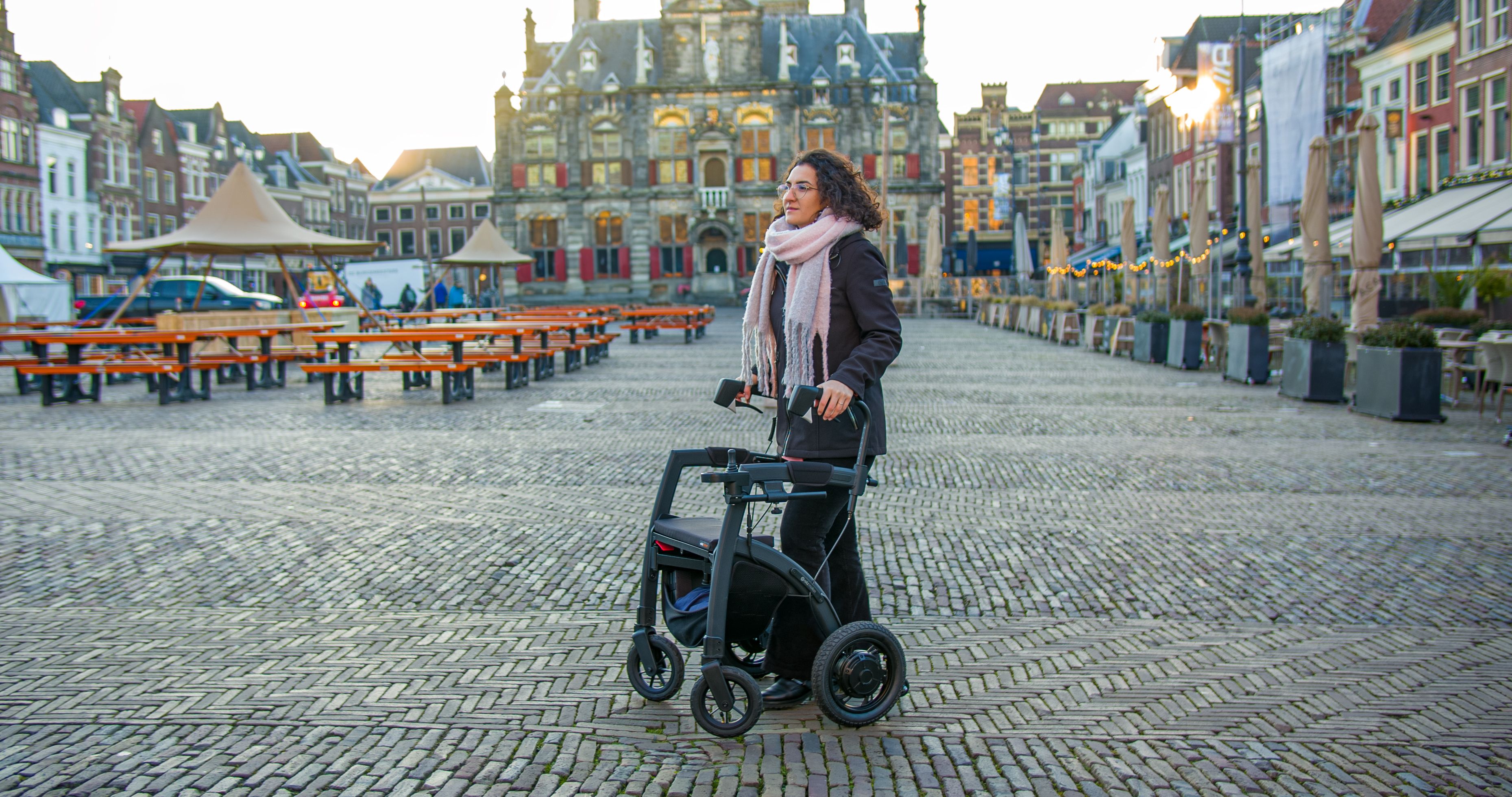 Woman in Jacket Walking with Walker on Cobblestone Pavement in Old Town ...