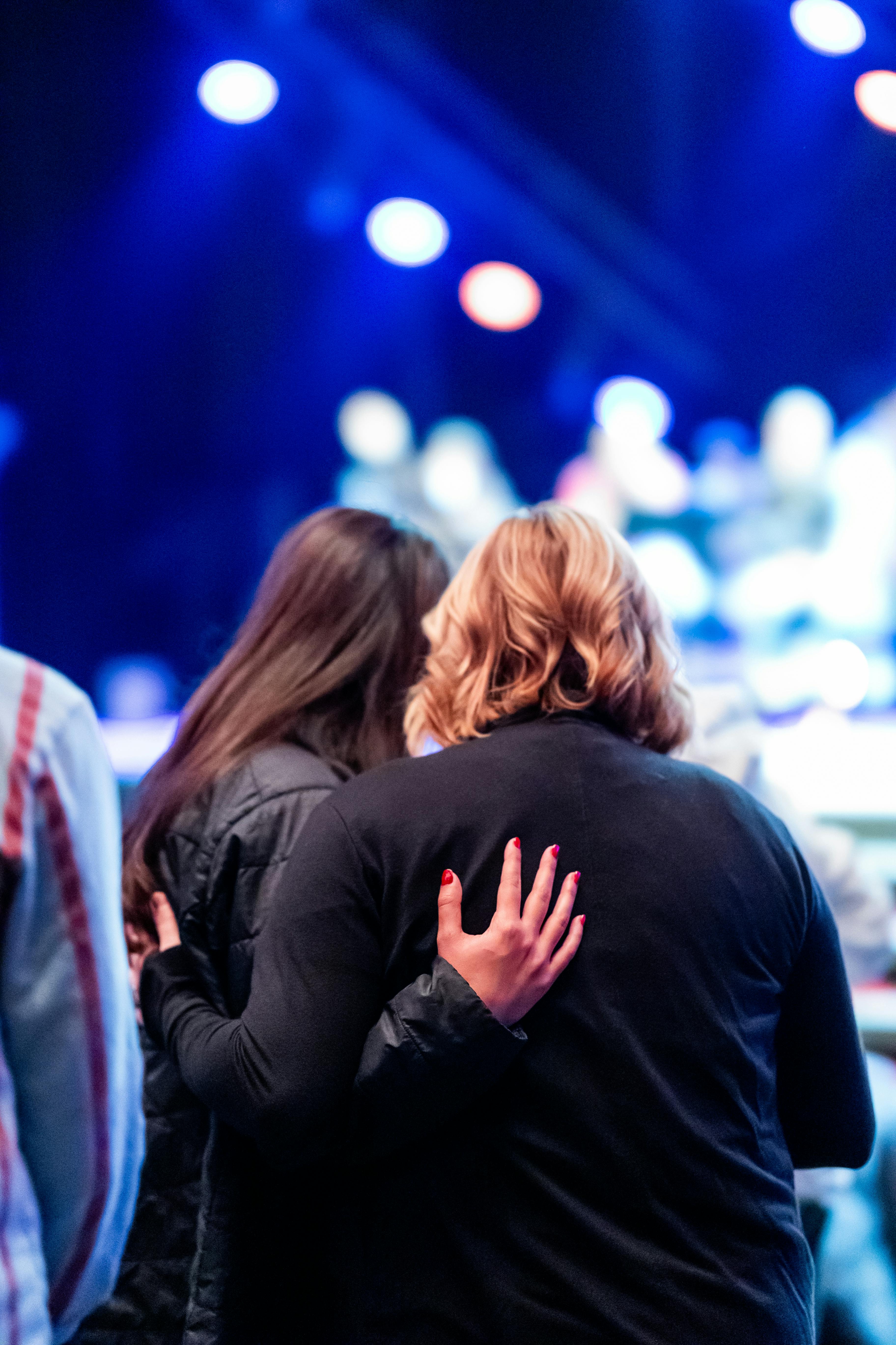Two people hugging at a concert · Free Stock Photo