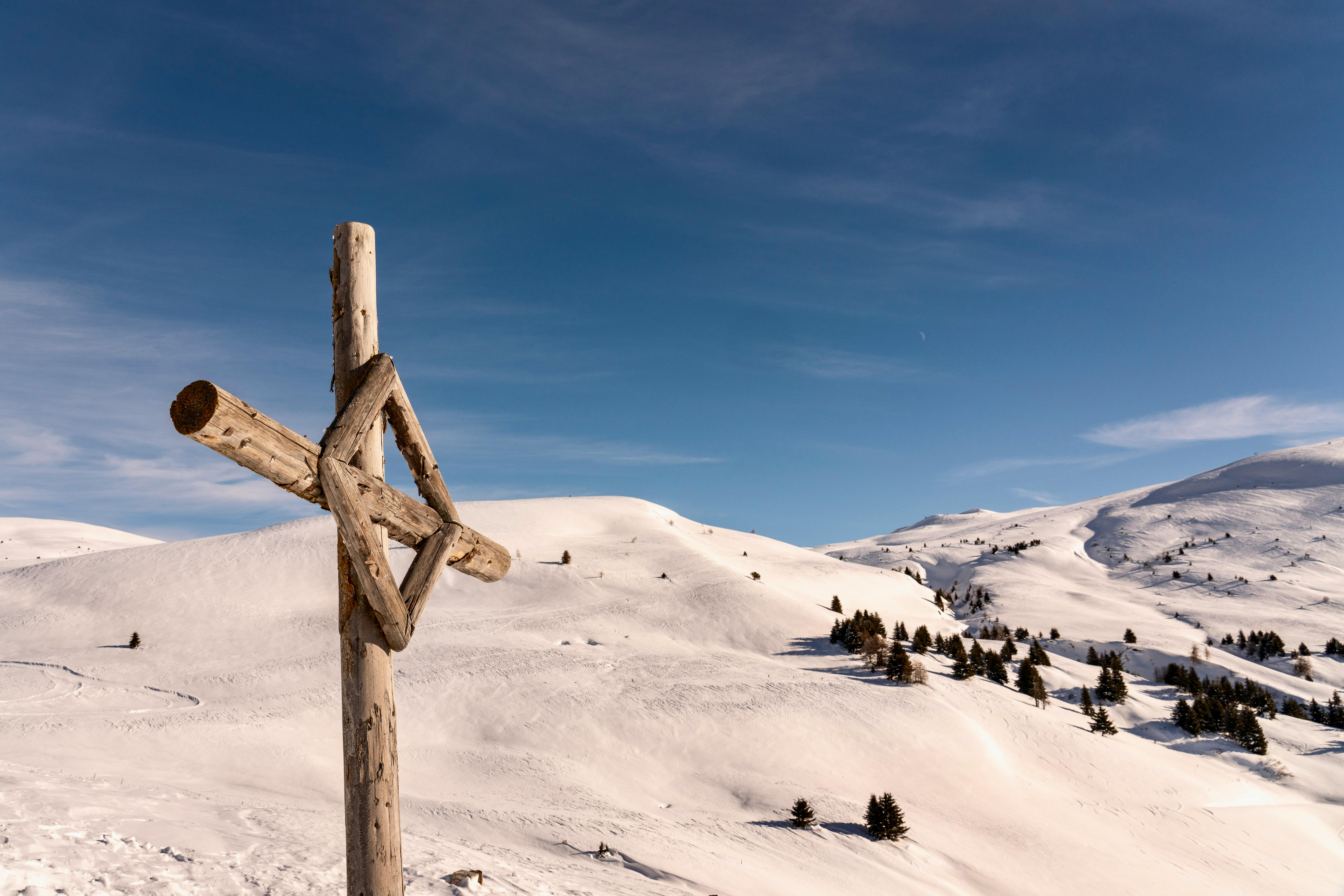 A wooden cross in the snow on a mountain · Free Stock Photo