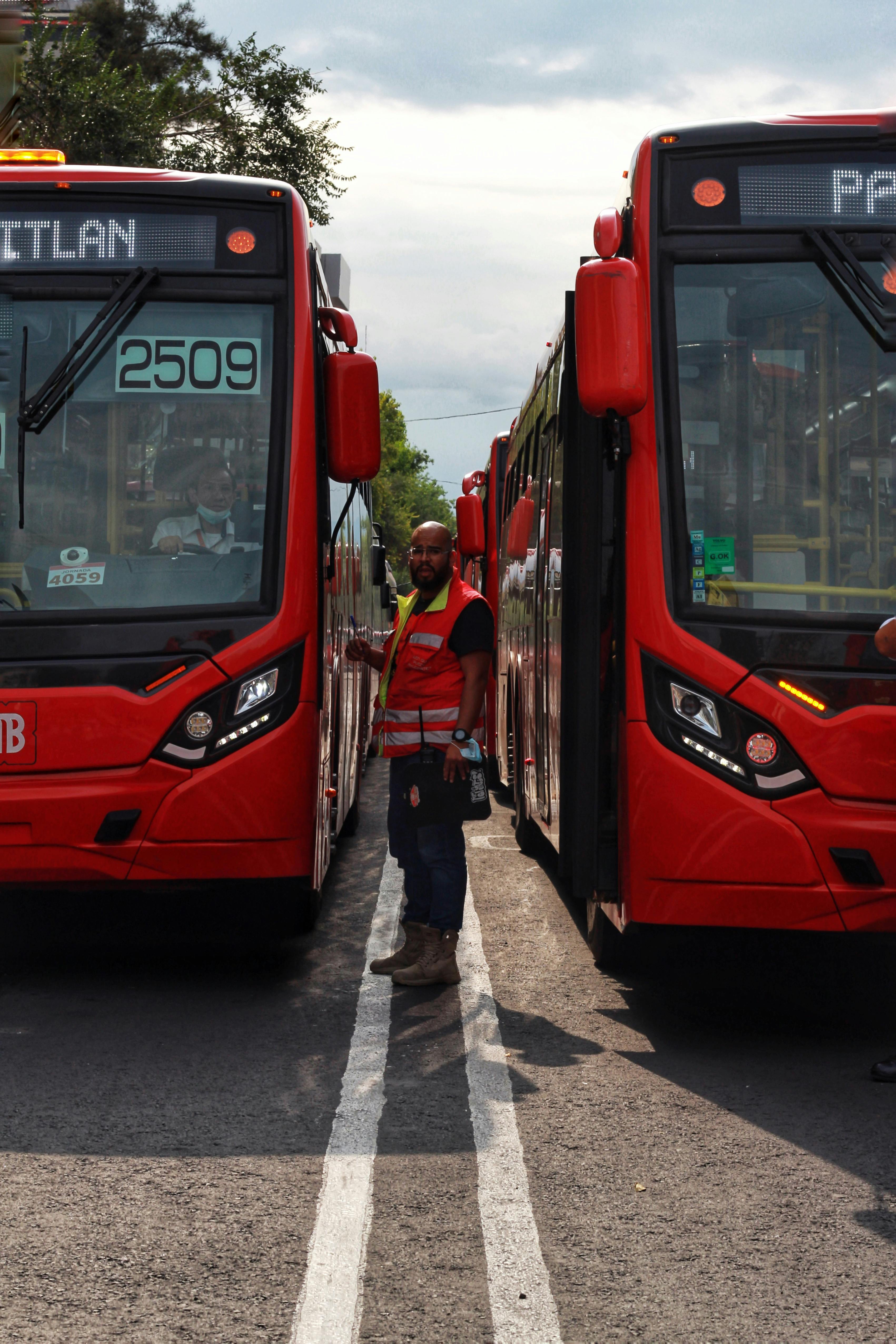 A Man Standing Between Two Buses · Free Stock Photo