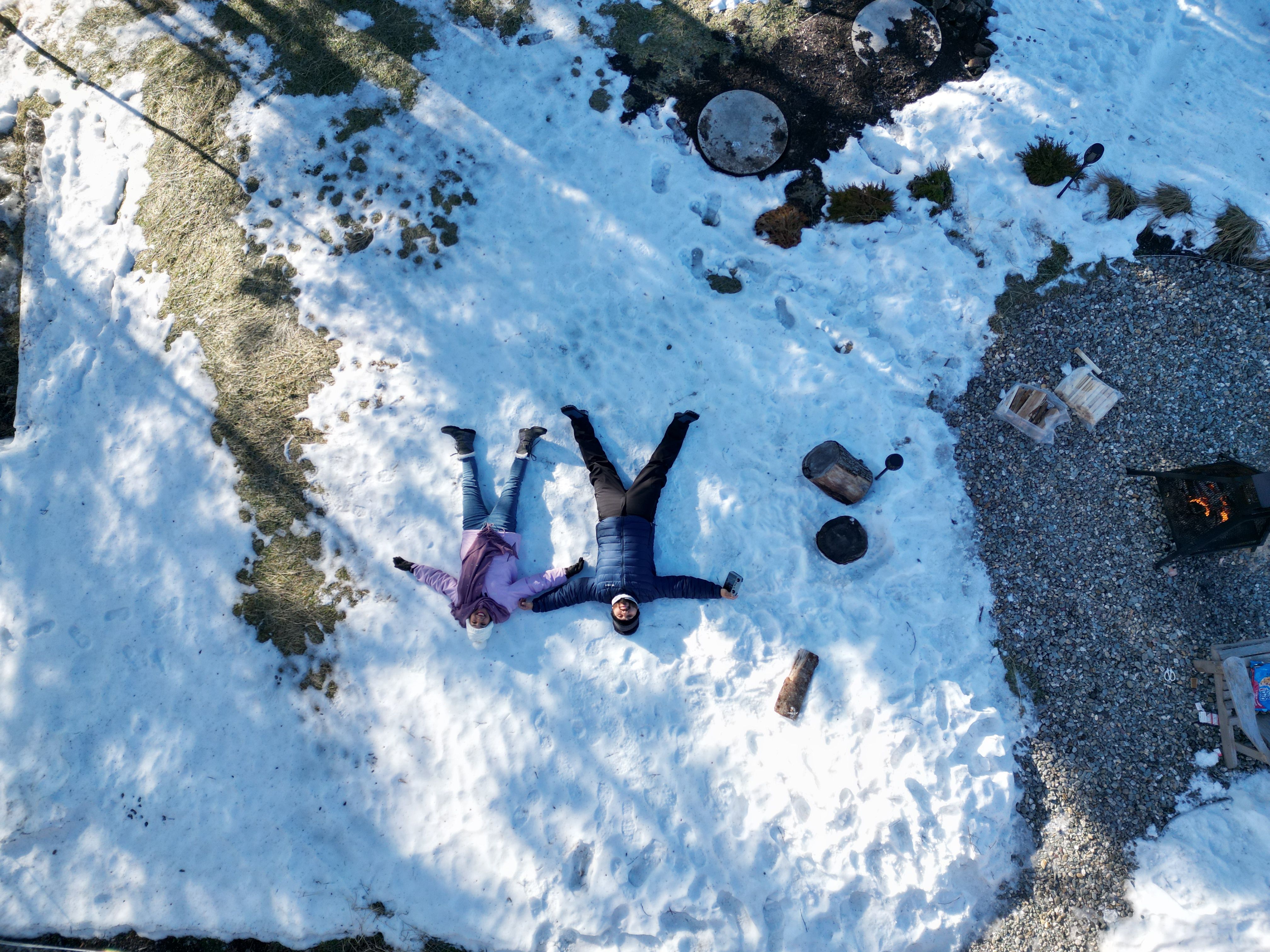 Drone Shot of Couple Lying on Snow · Free Stock Photo
