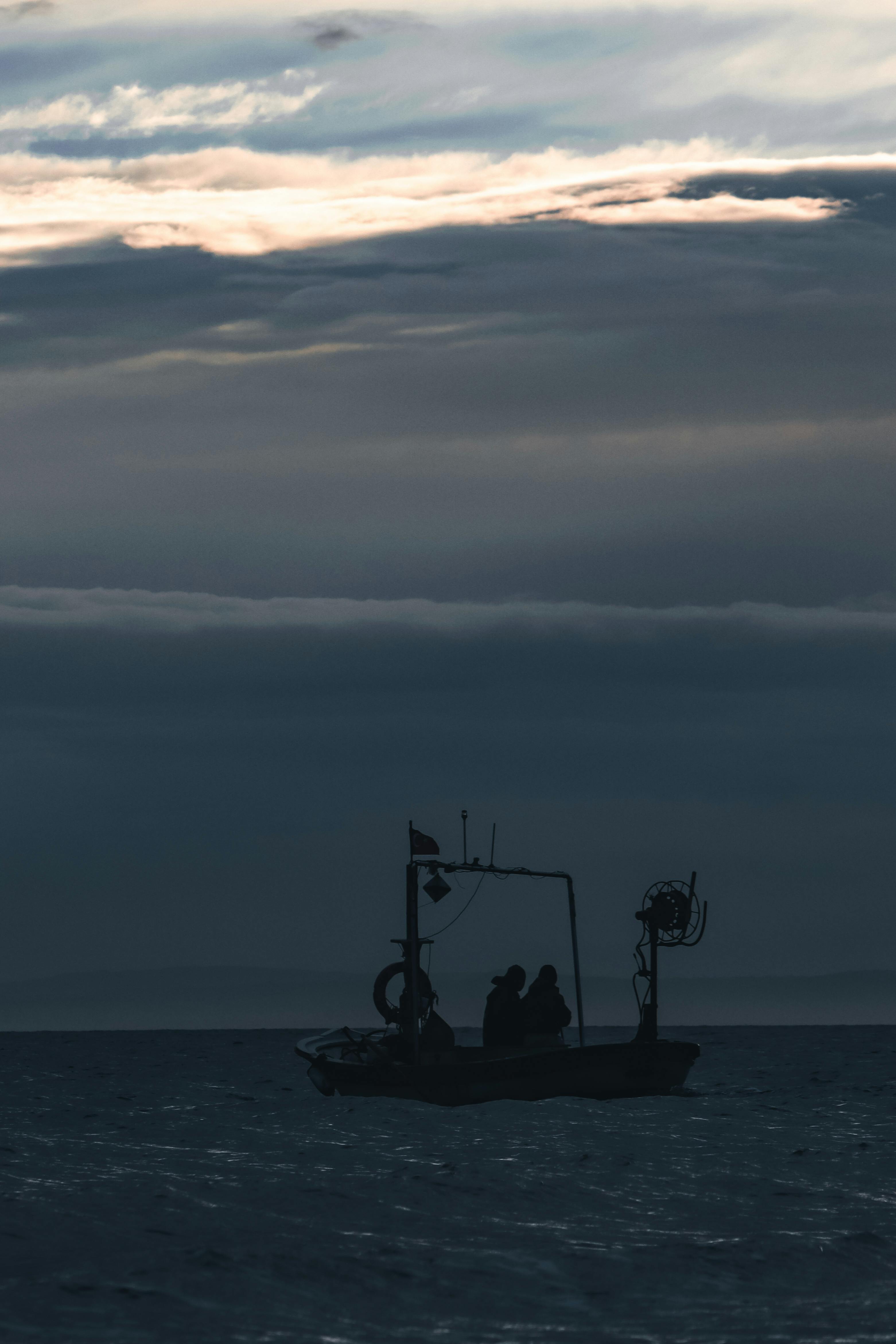 A Man Rowing A Small Boat With a Sail · Free Stock Photo