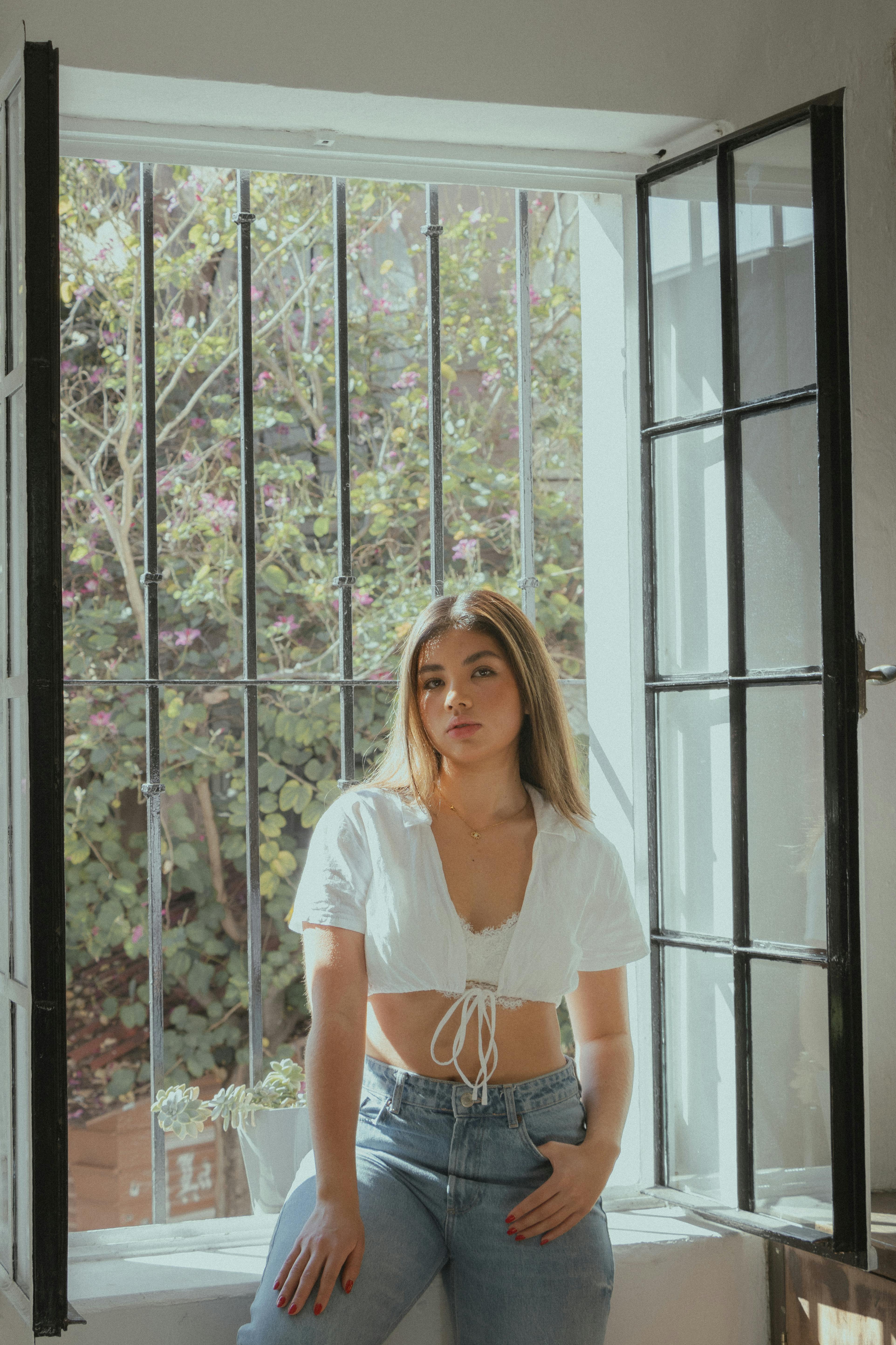 Woman in White Crop Top Sitting on Windowsill · Free Stock Photo