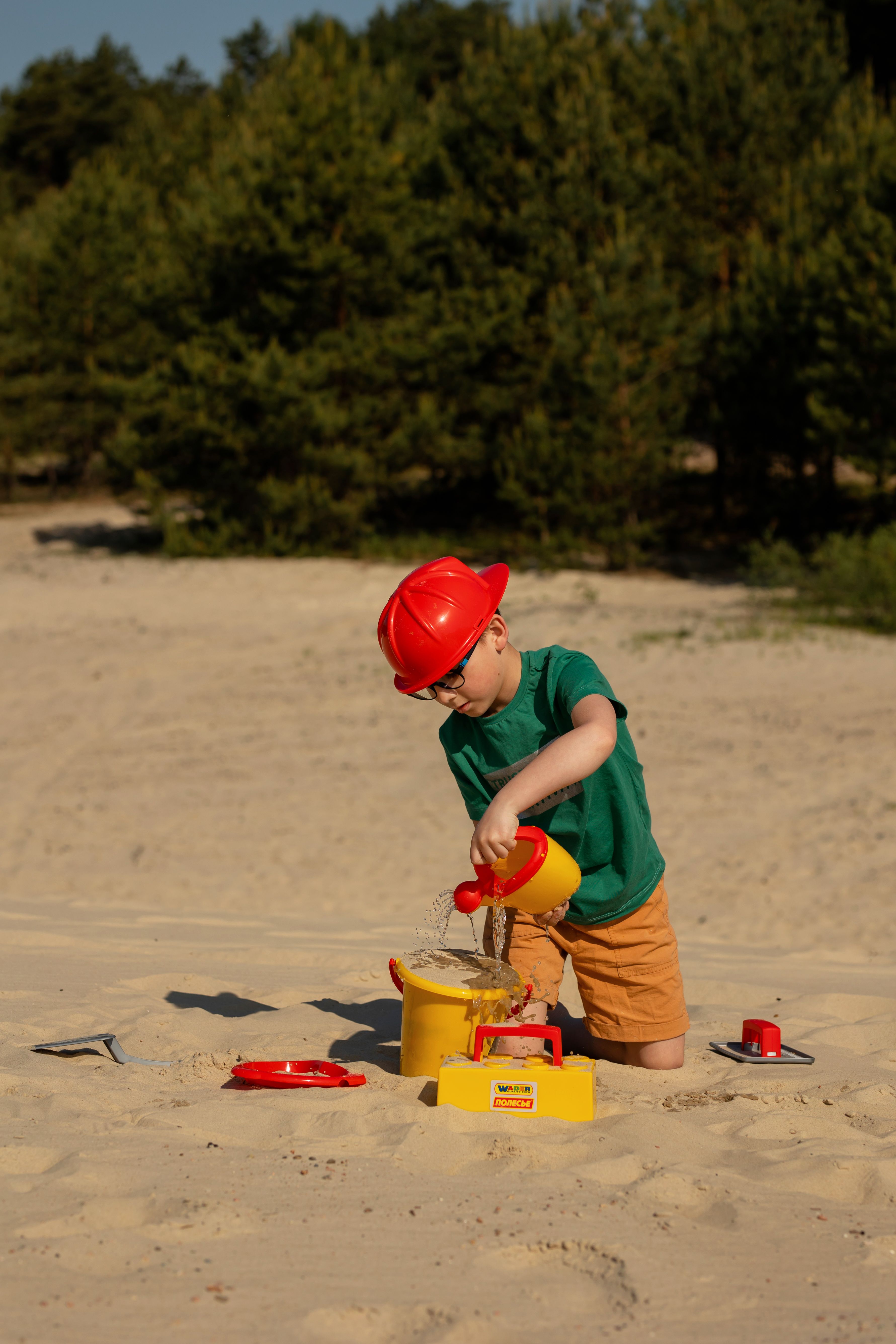 Boy Watering Bucket with Sand · Free Stock Photo