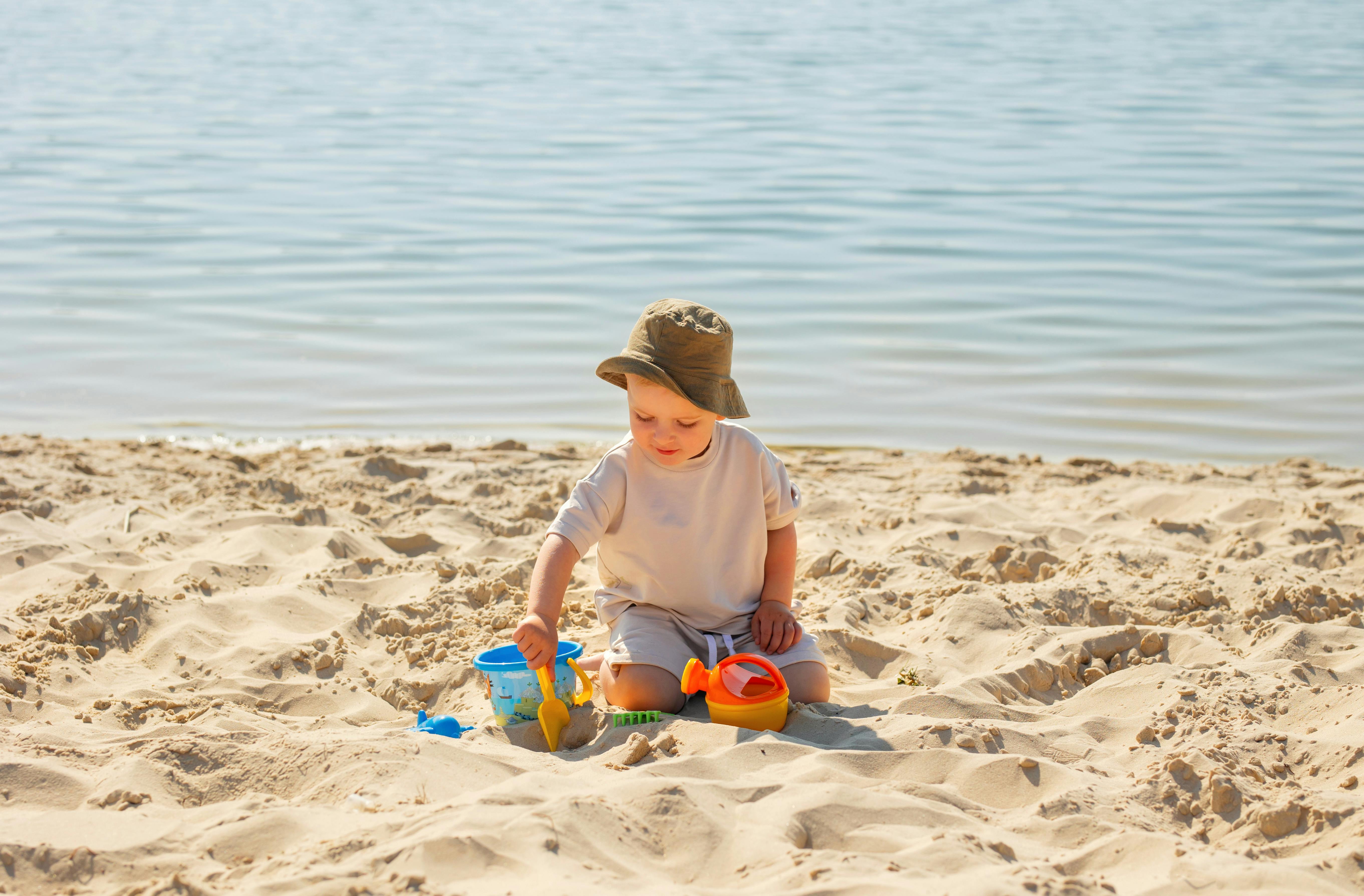 Boy Digging in Sand on Beach · Free Stock Photo
