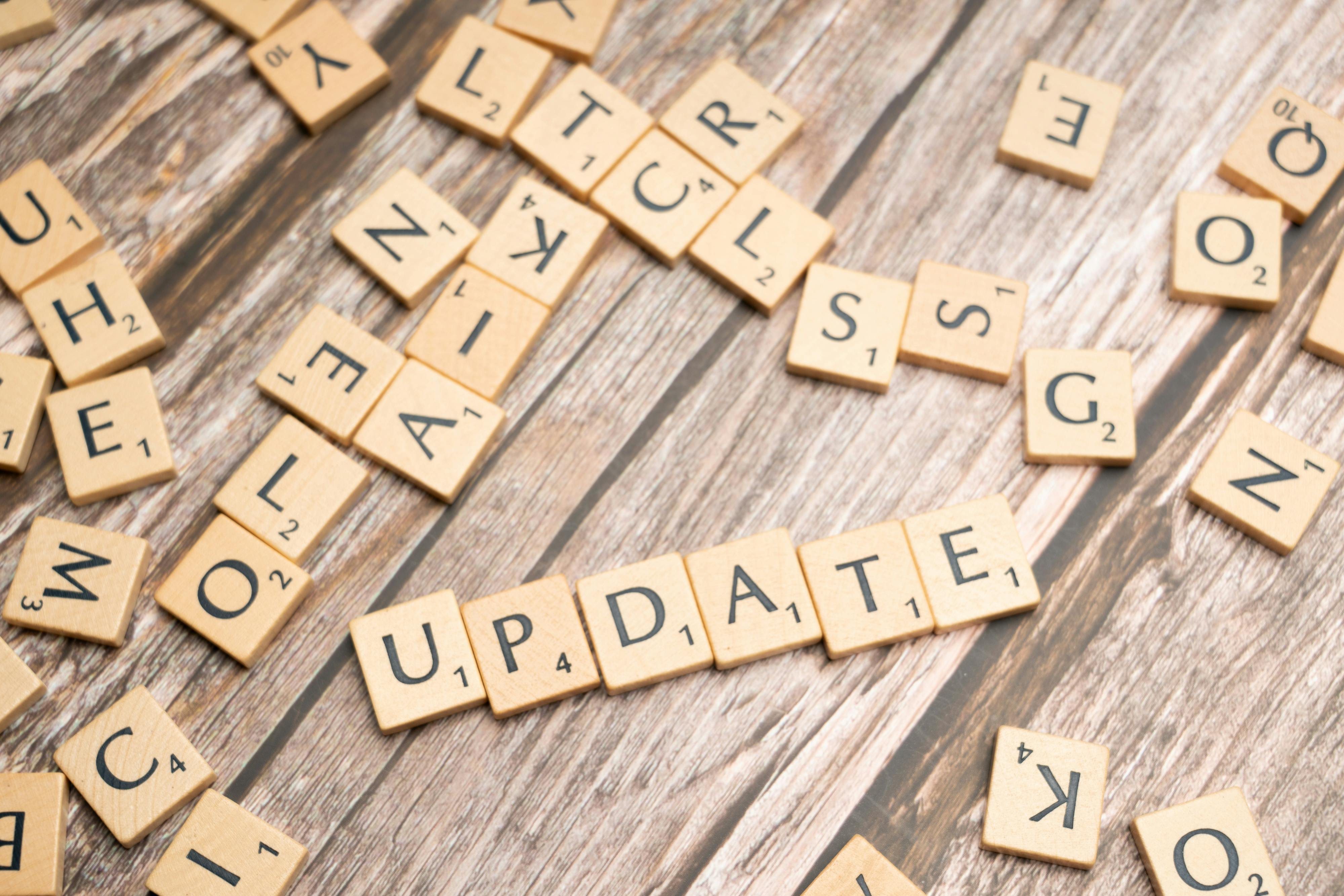 Scrabble letters spelling the word update on a wooden table · Free ...