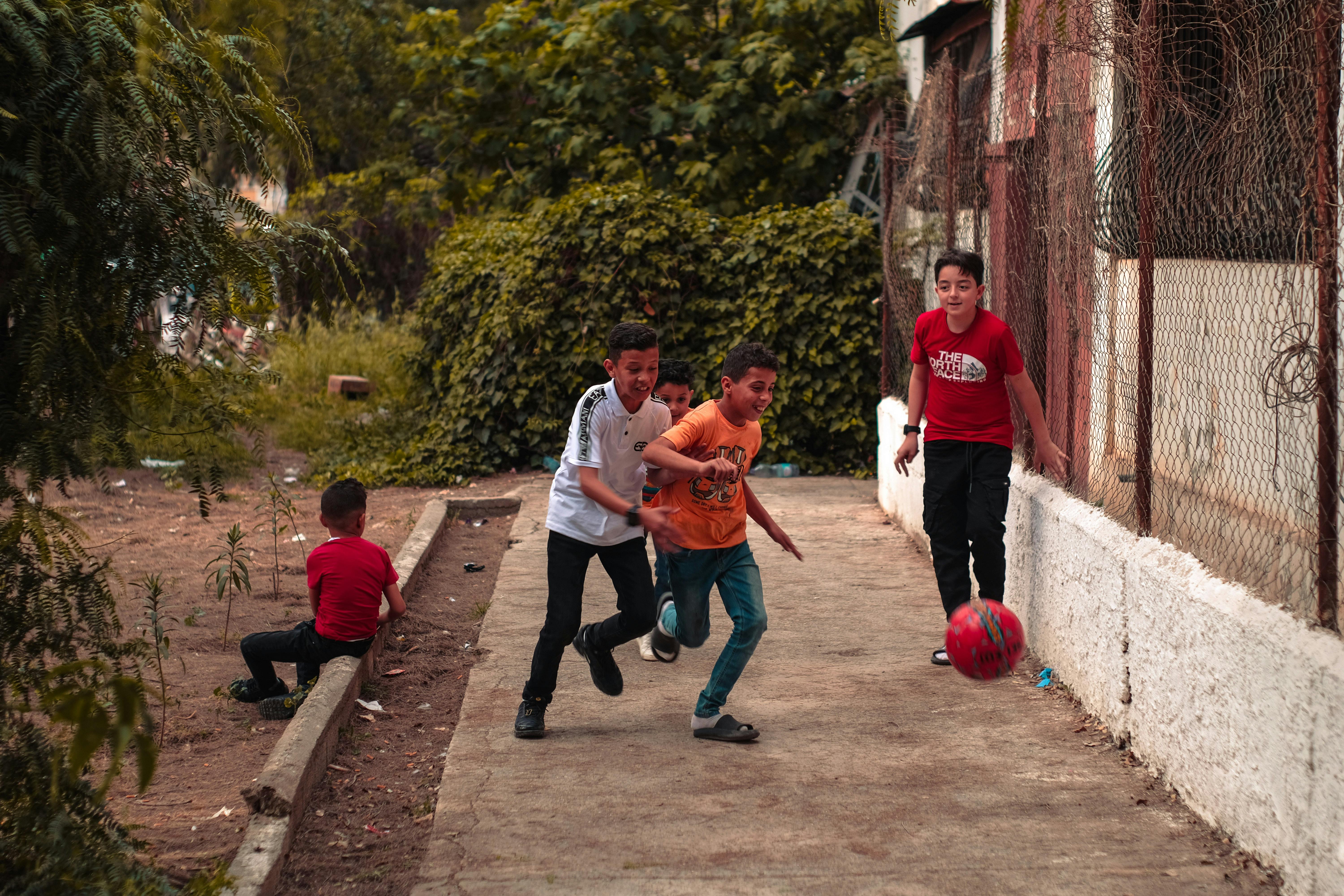 Boys Playing Football on a Pavement · Free Stock Photo