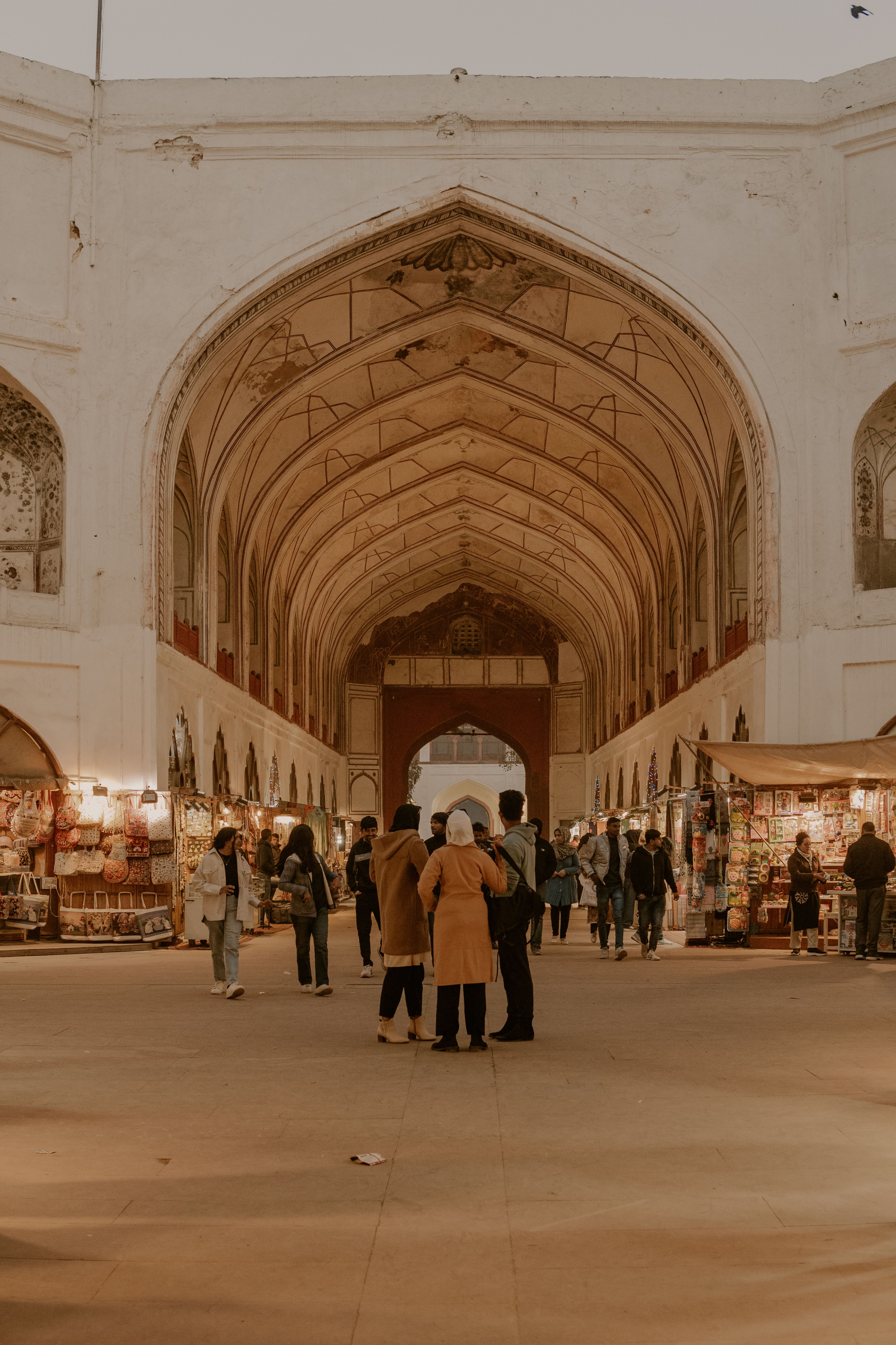 People walking through an arched walkway in a market · Free Stock Photo