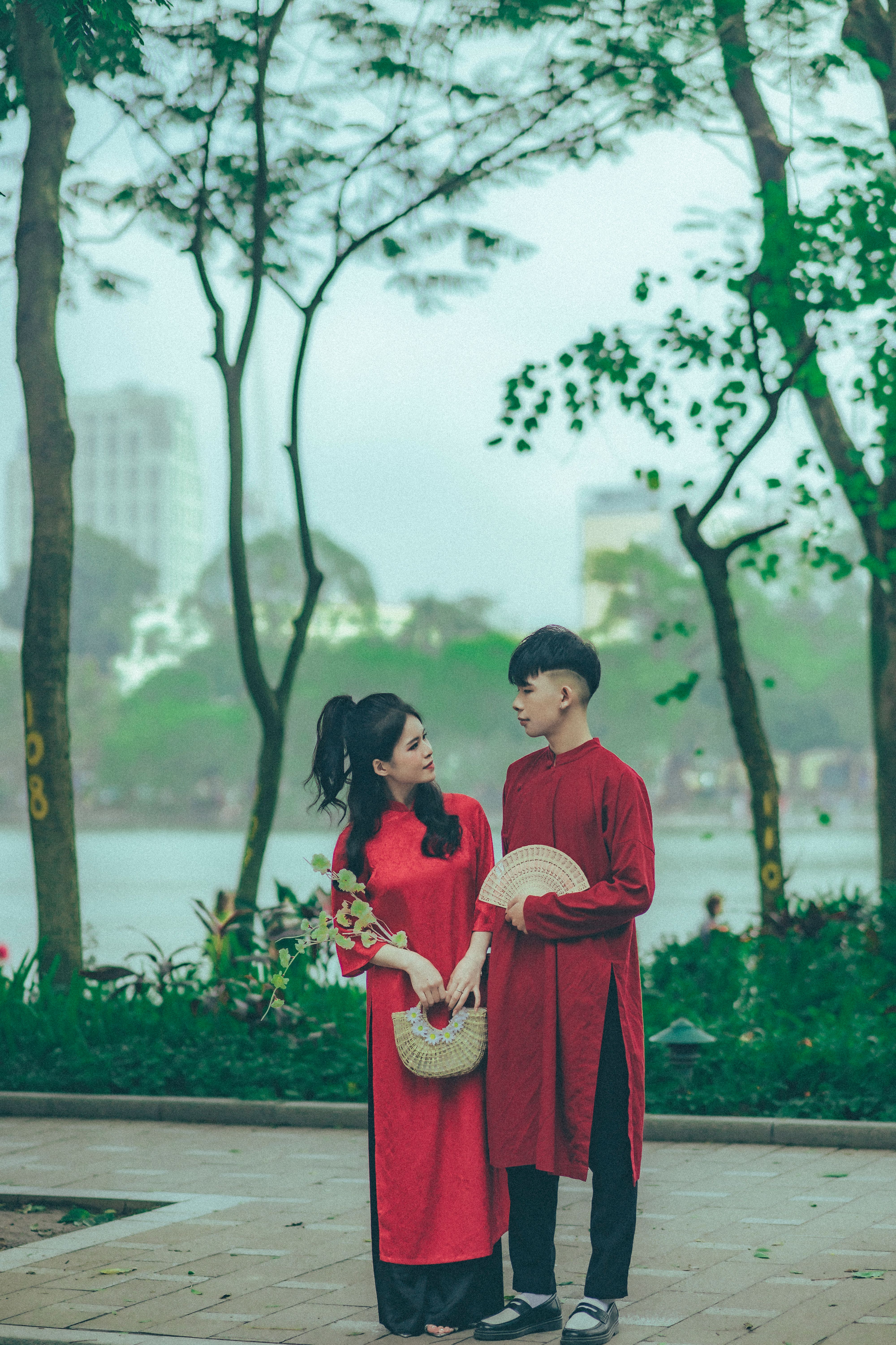 Couple Wearing Red Gowns in a Park · Free Stock Photo