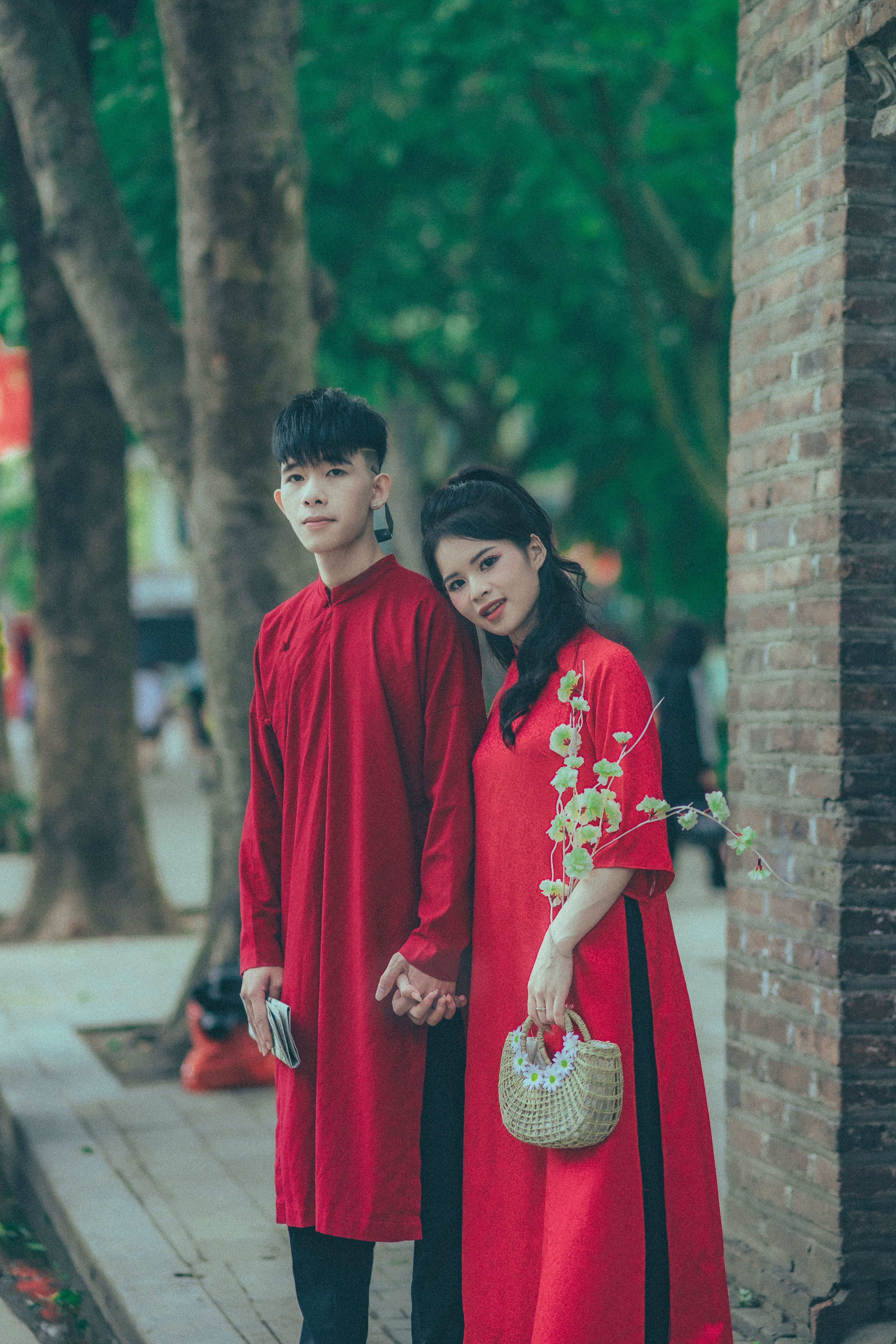 Couple Wearing Red Gowns in a Park · Free Stock Photo