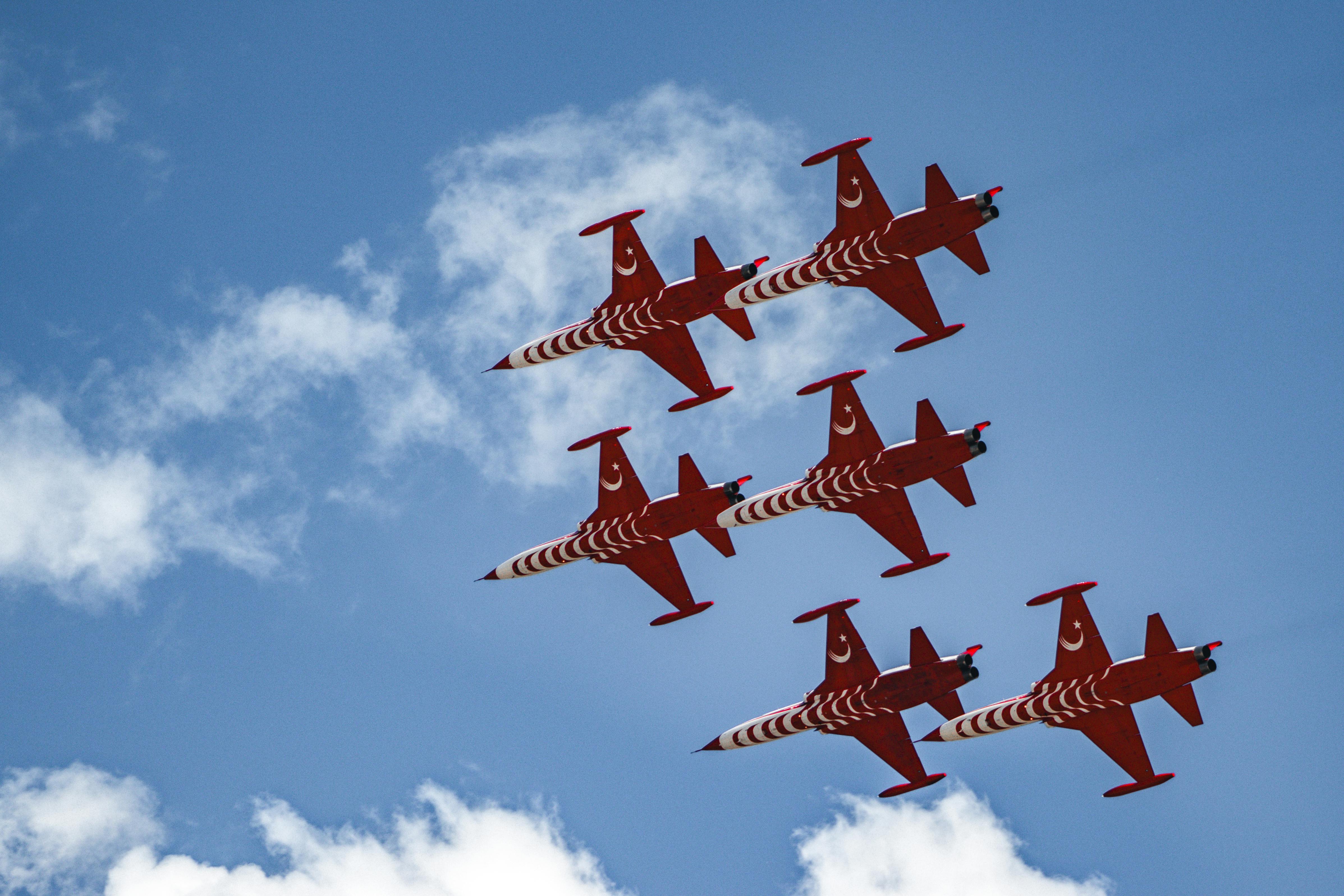 A group of red and white planes flying in formation · Free Stock Photo