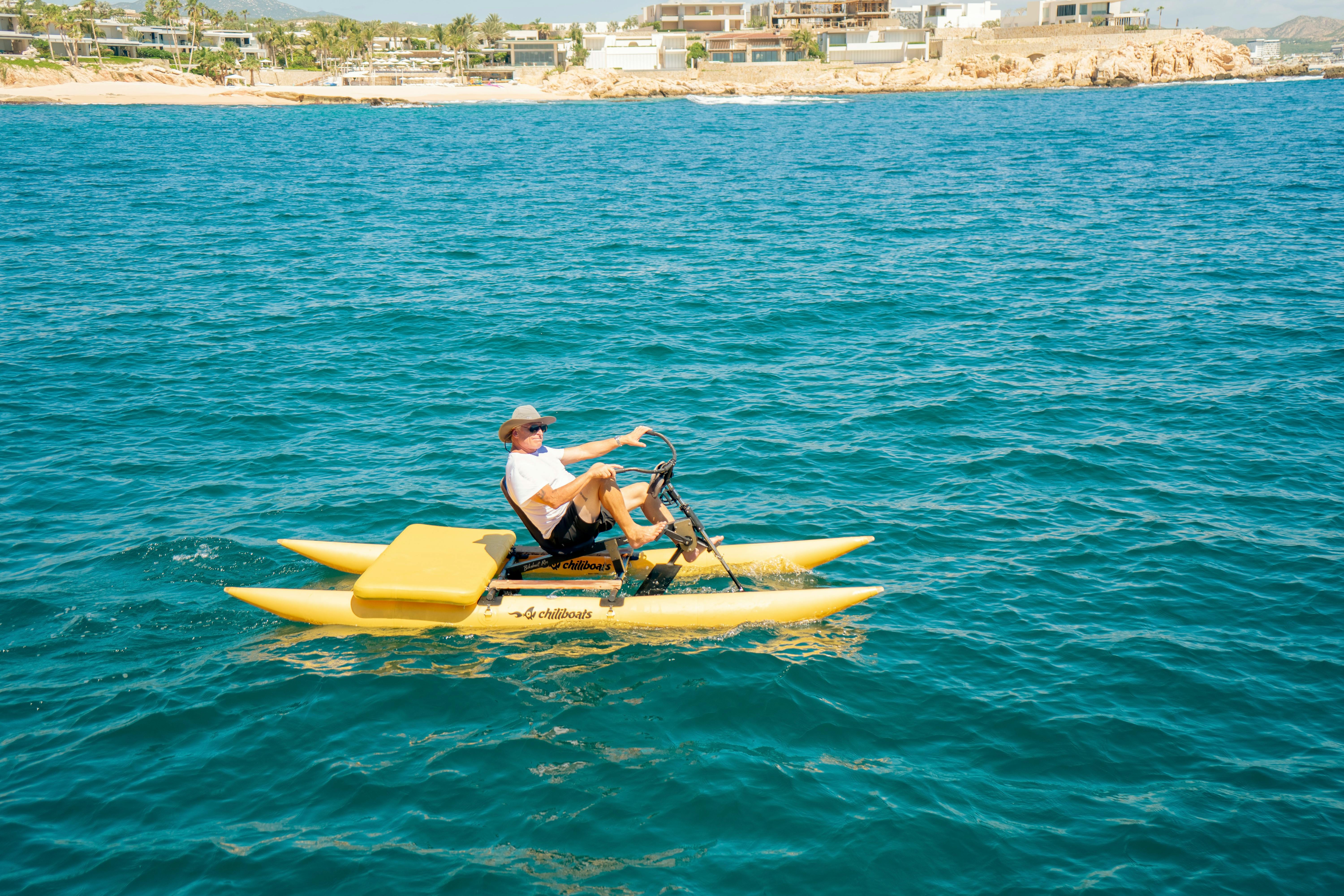 A man riding a yellow kayak in the ocean · Free Stock Photo