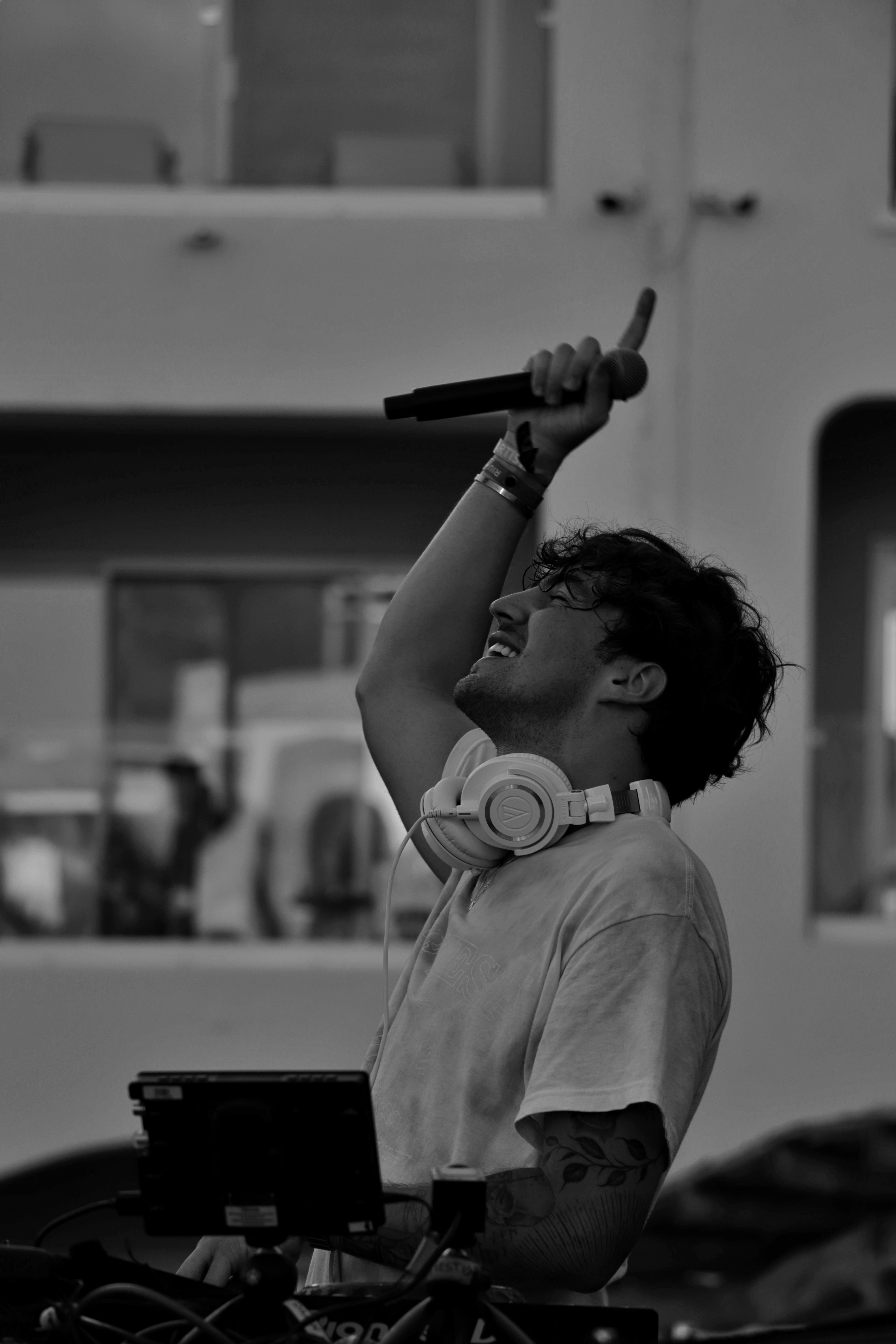 DJ with Microphone in Raised Arm in Black and White · Free Stock Photo