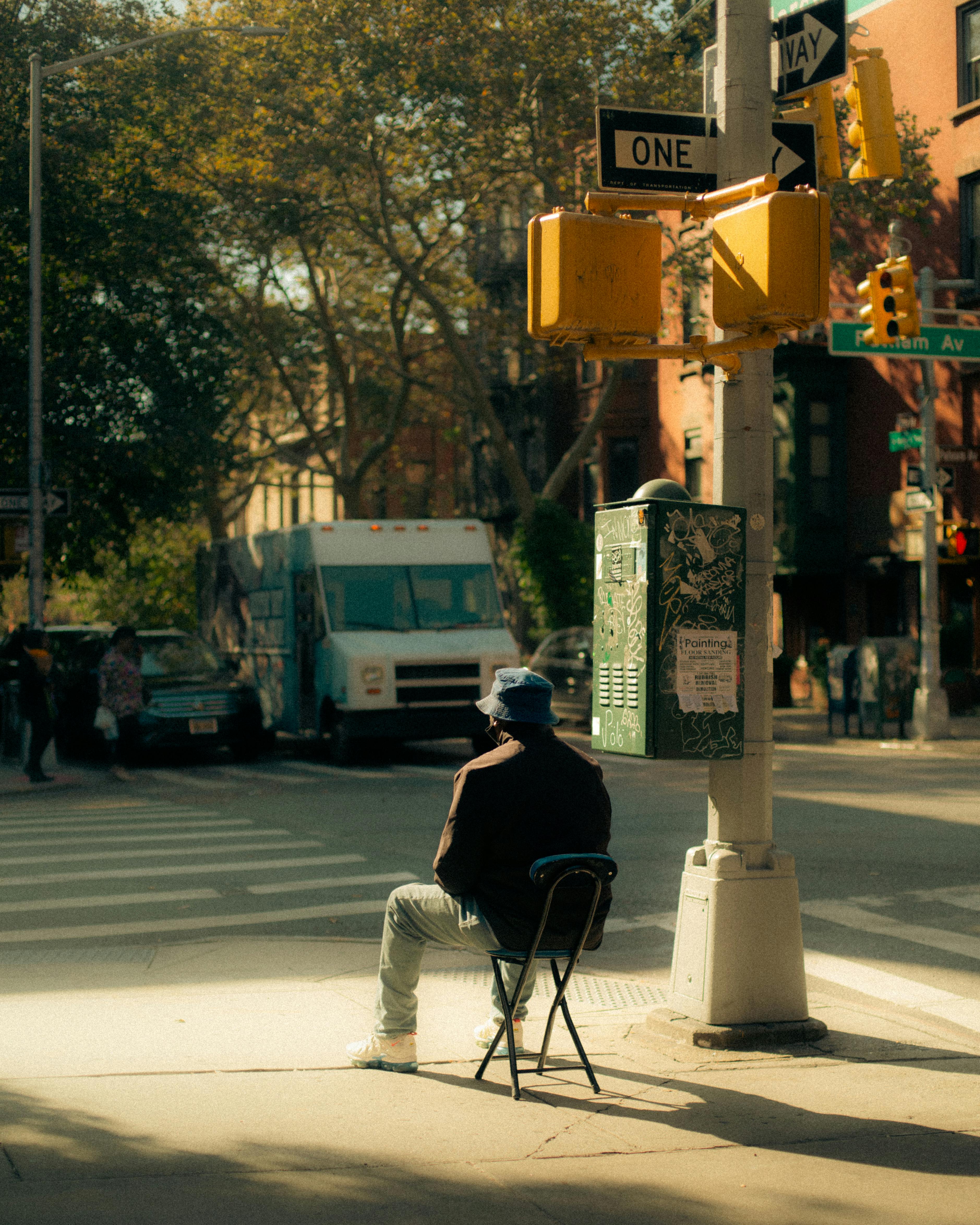 Man Sitting on Chair near Street in City · Free Stock Photo