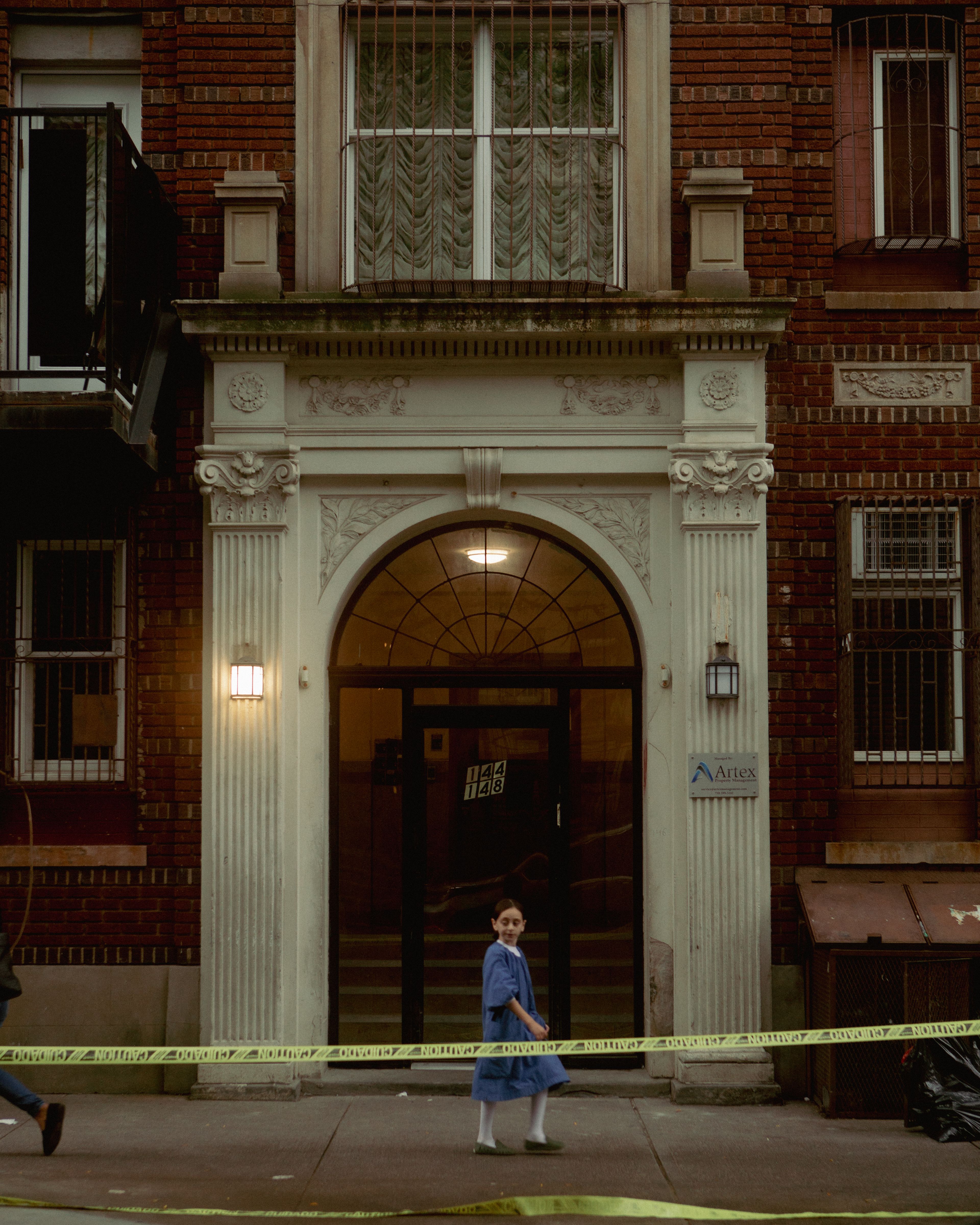 Girl Walking behind Barricade Tape near Building Entrance · Free Stock ...