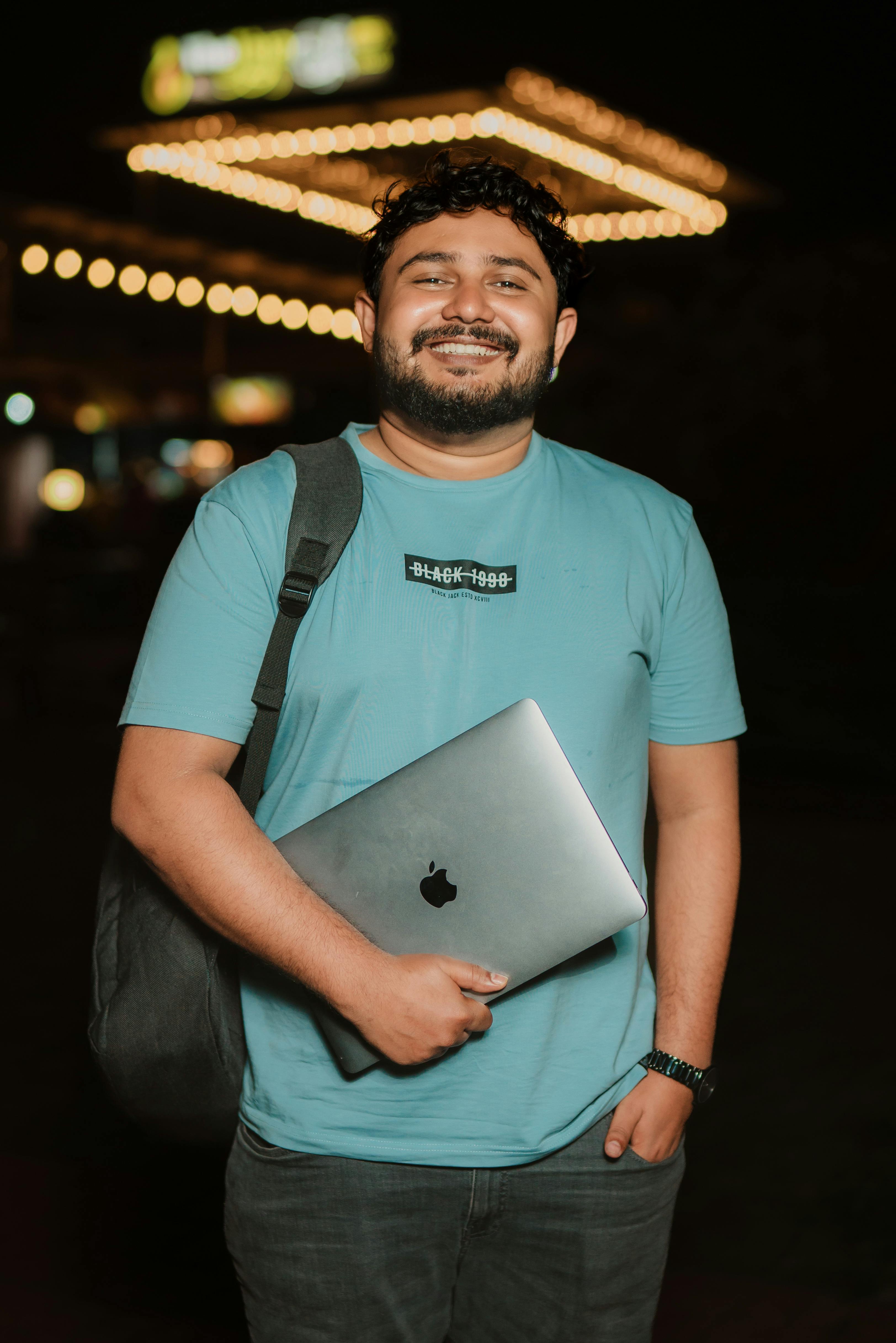 Smiling Geek with Laptop in Hand · Free Stock Photo