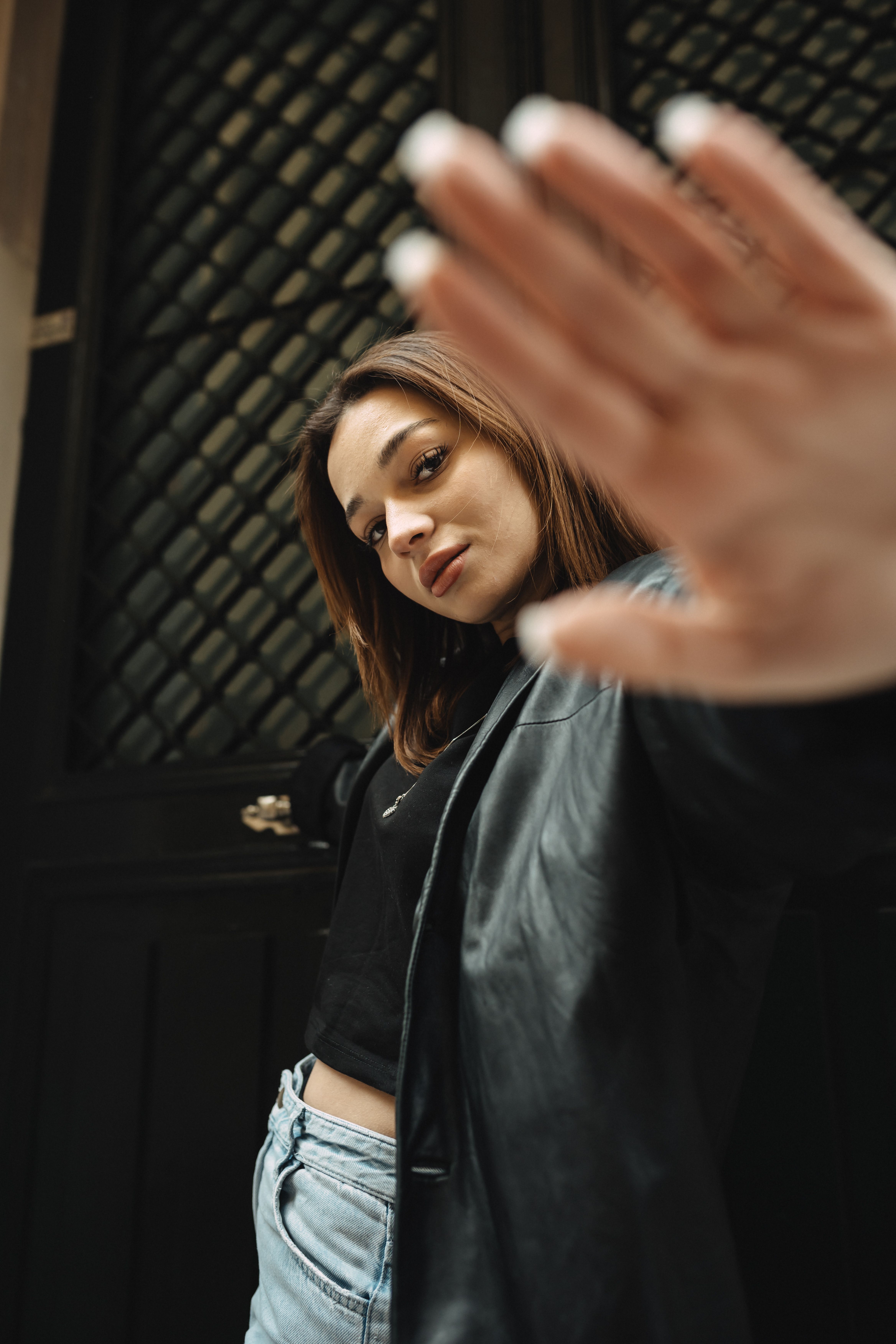 Woman in Jacket and with Hand Raised · Free Stock Photo