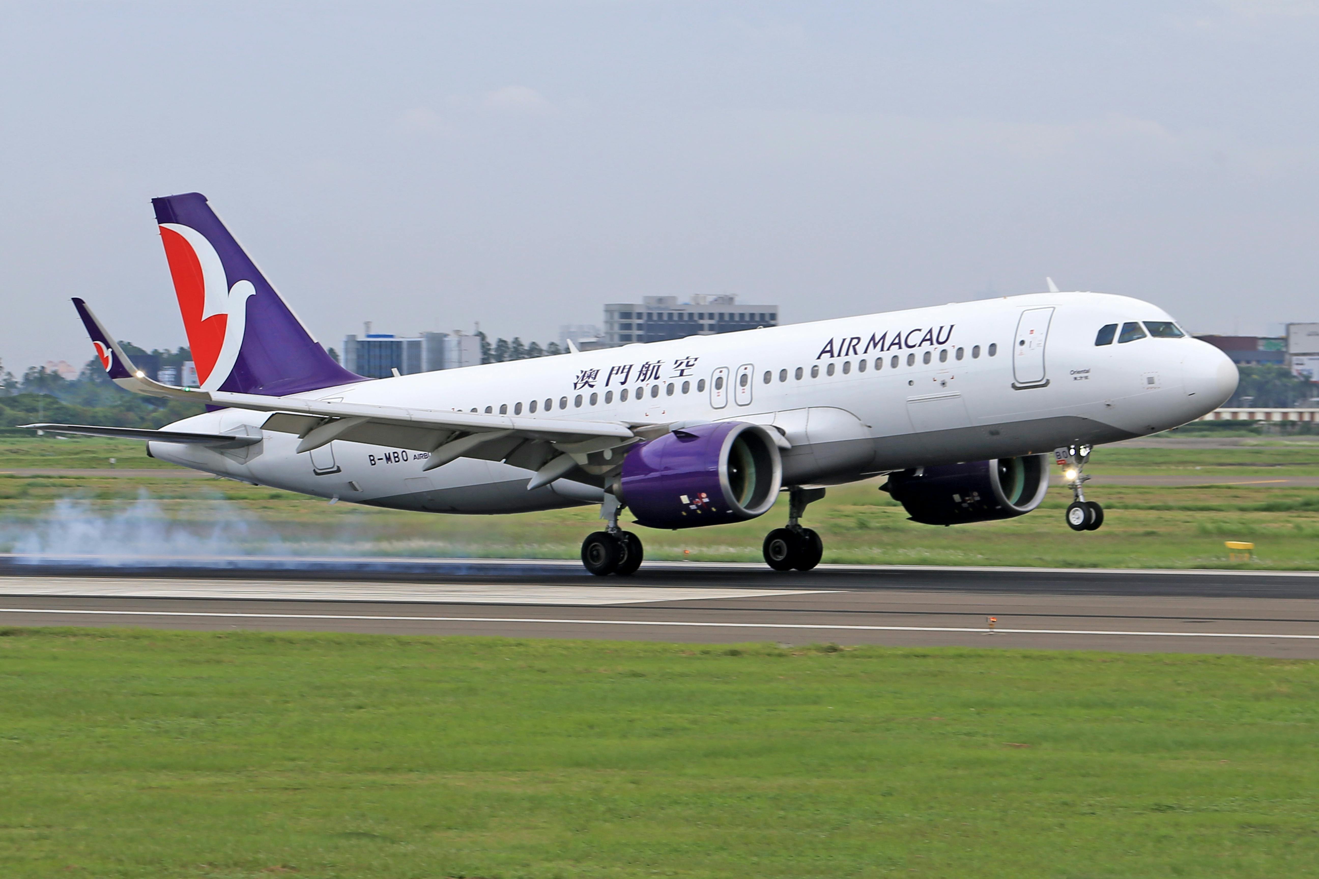 A purple and white airplane taking off from an airport runway · Free ...