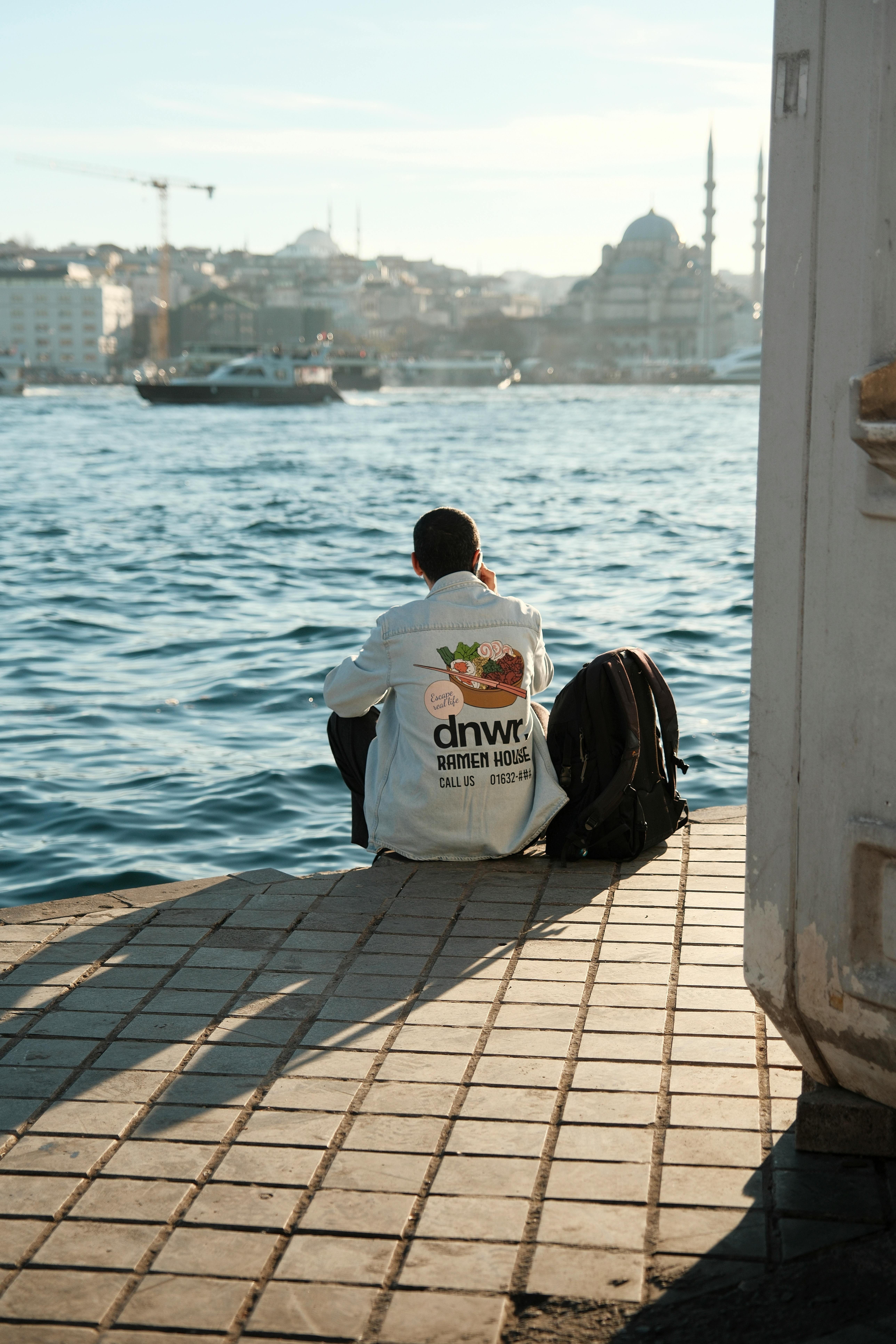 Back View of a Man Sitting on the Shore of the Bosphorus Strait in ...