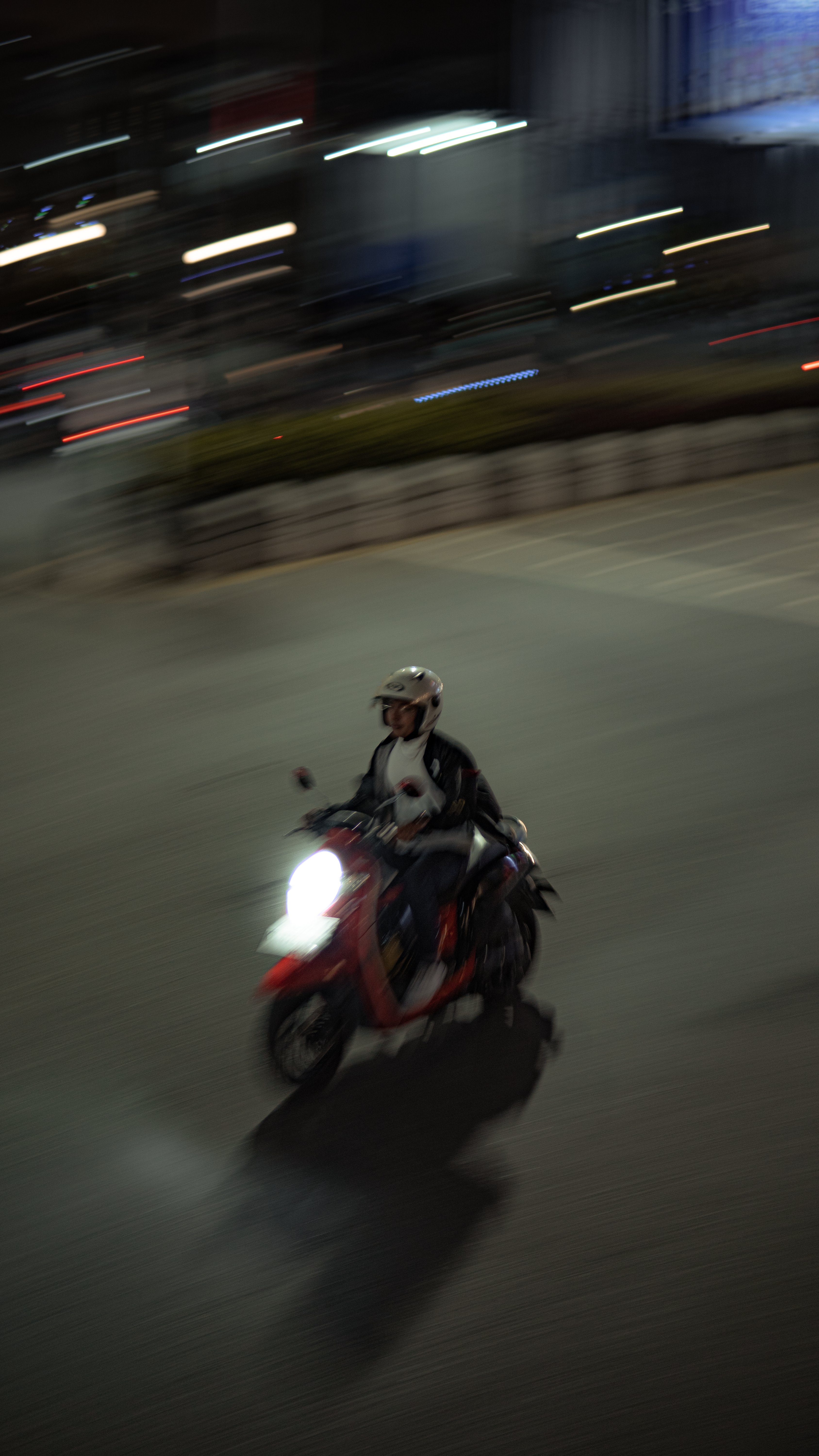 A Man Riding on a Motor Scooter on a Street at Night · Free Stock Photo