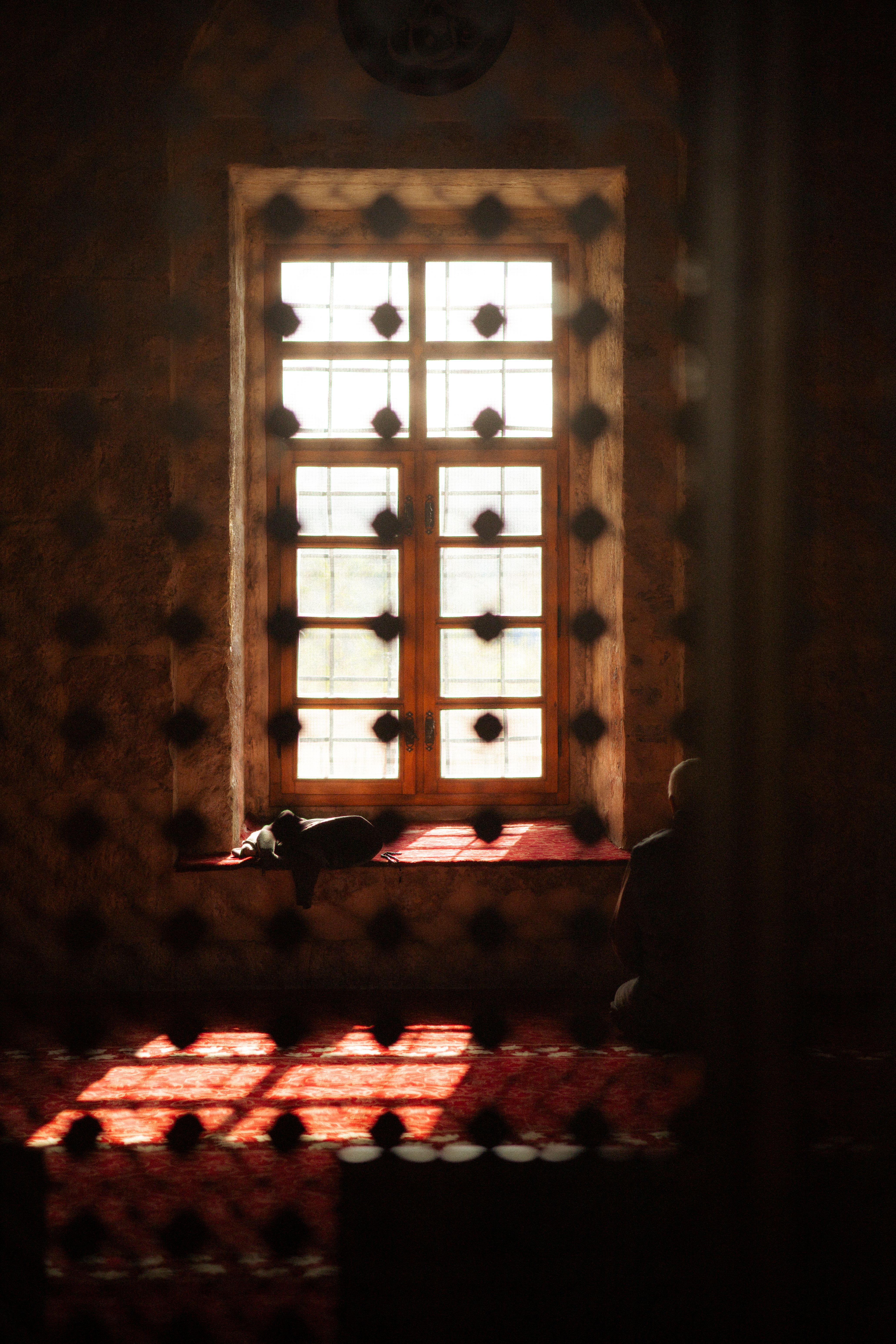 Man Praying by the Window in a Mosque · Free Stock Photo