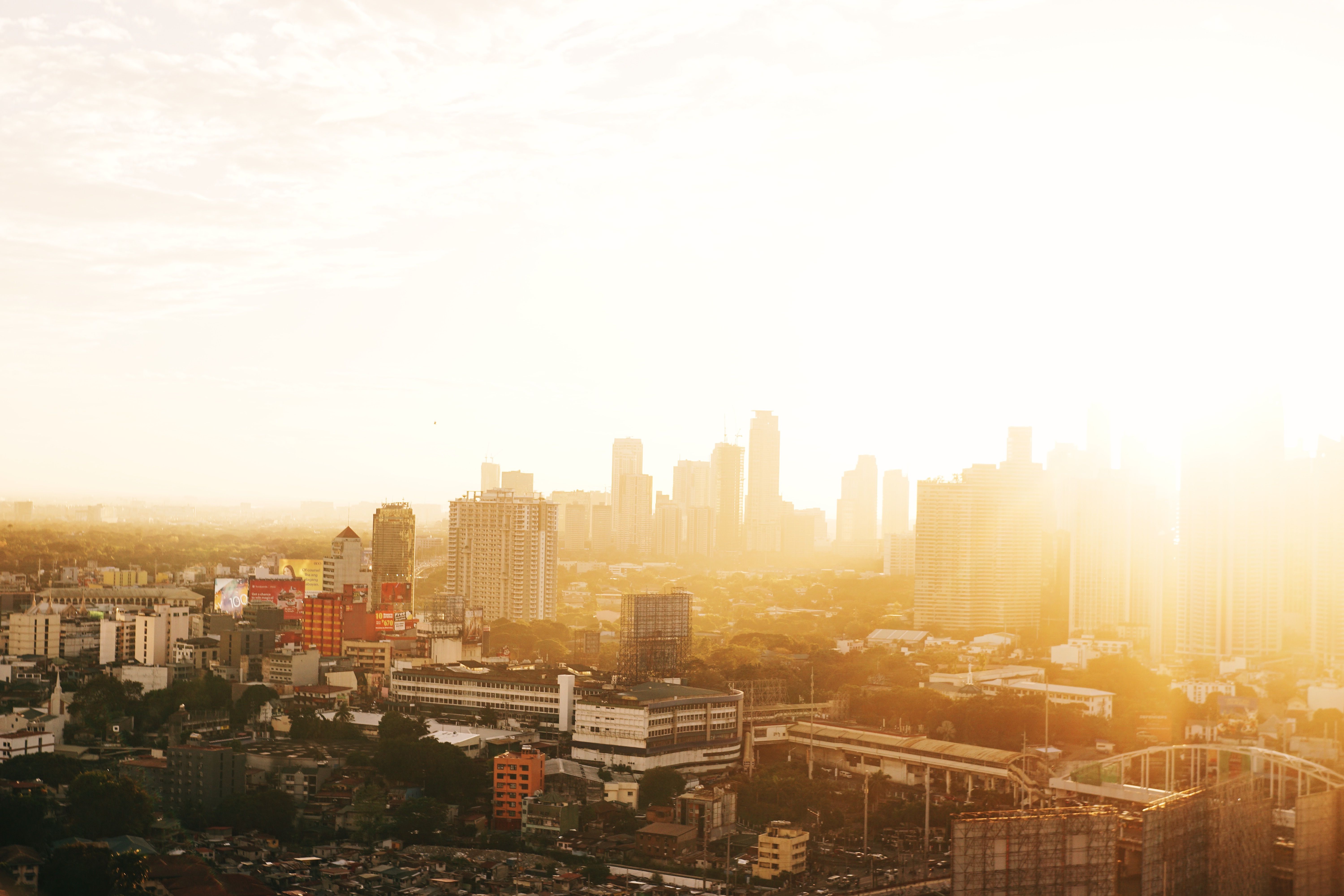 A city skyline with a sun setting over it · Free Stock Photo