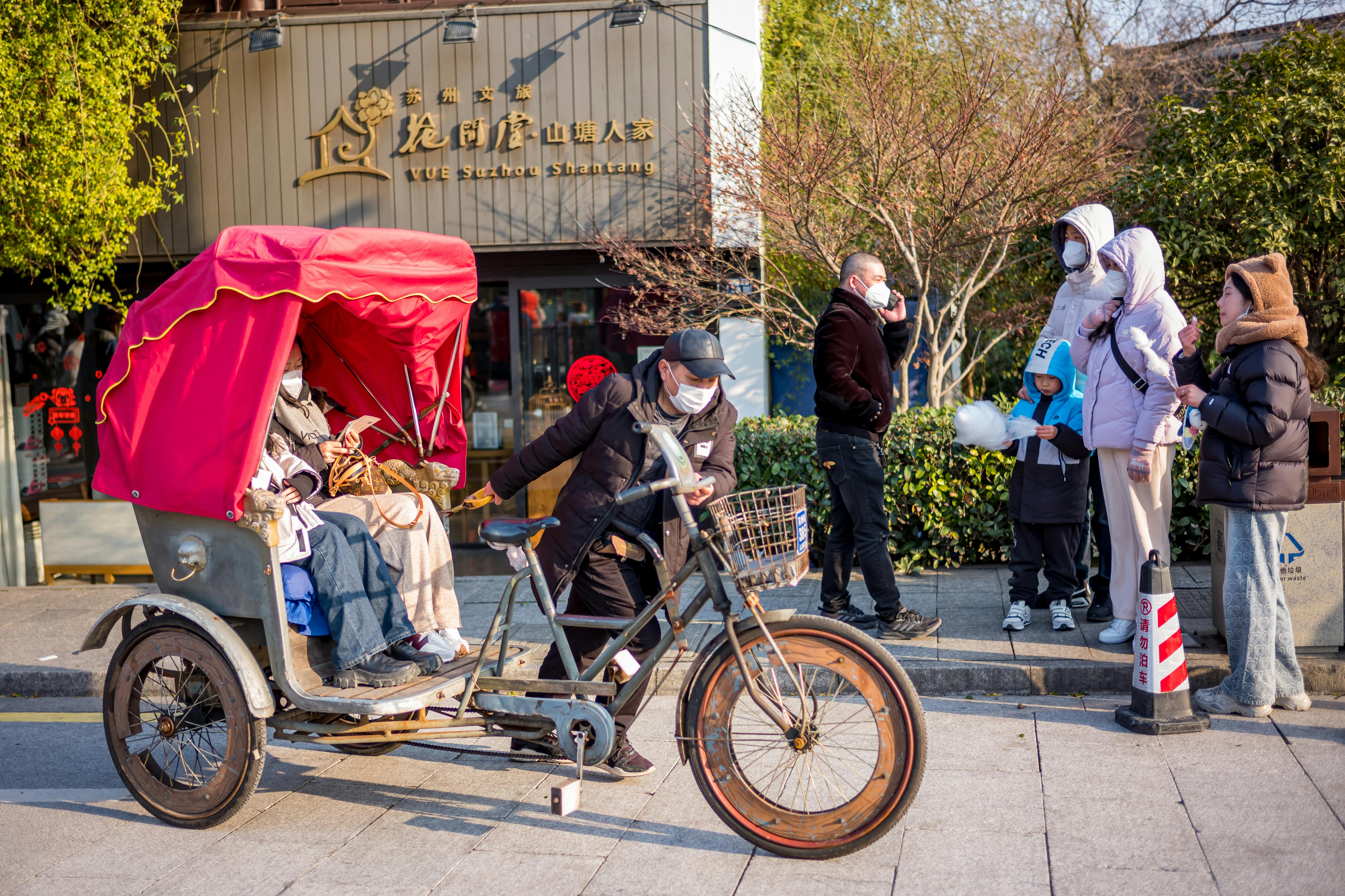 Man Pushing a Rickshaw with Passengers in a Chinese City · Free Stock Photo