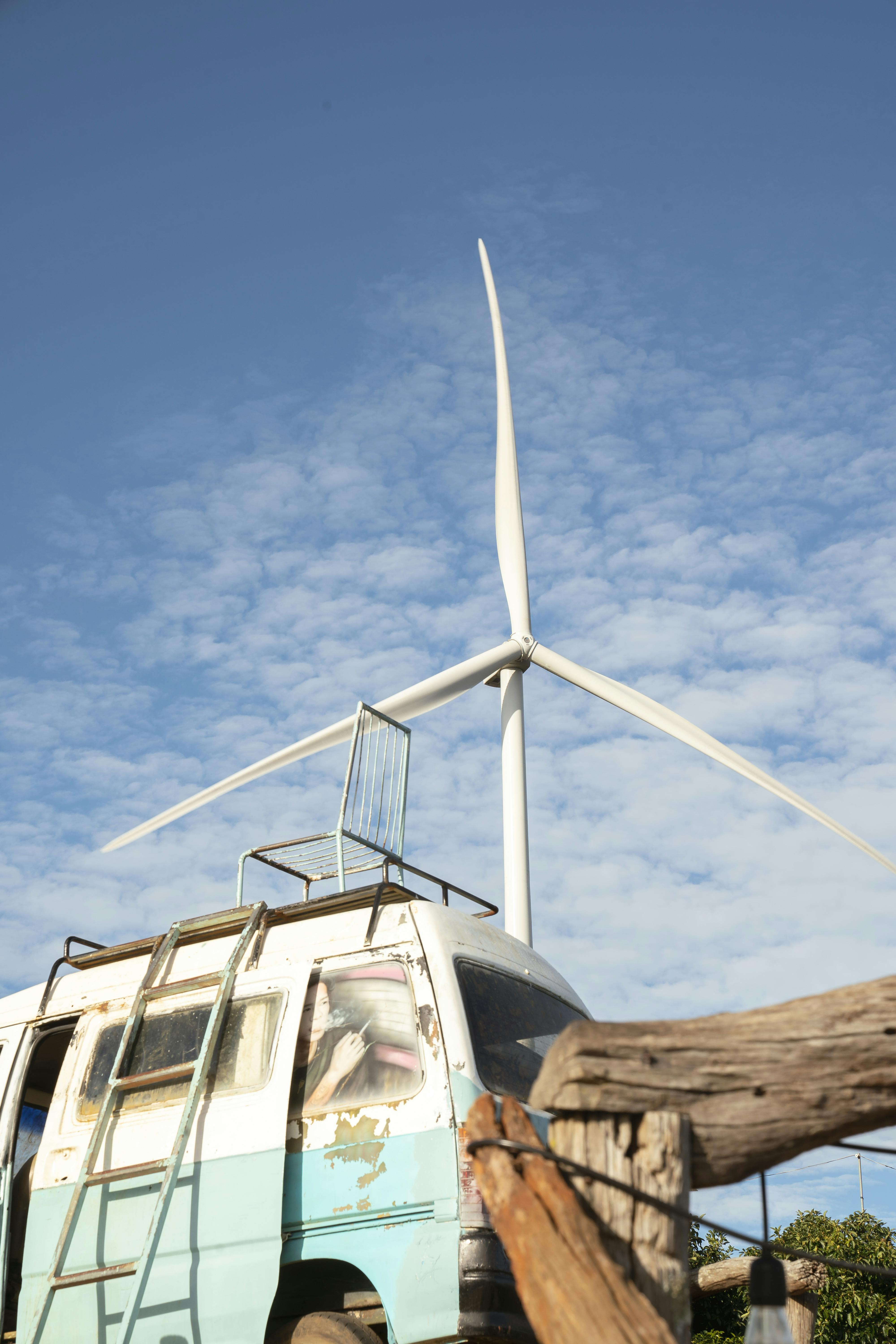 Wind Turbine behind Van Wreckage with Ladder and Chair on Roof · Free ...