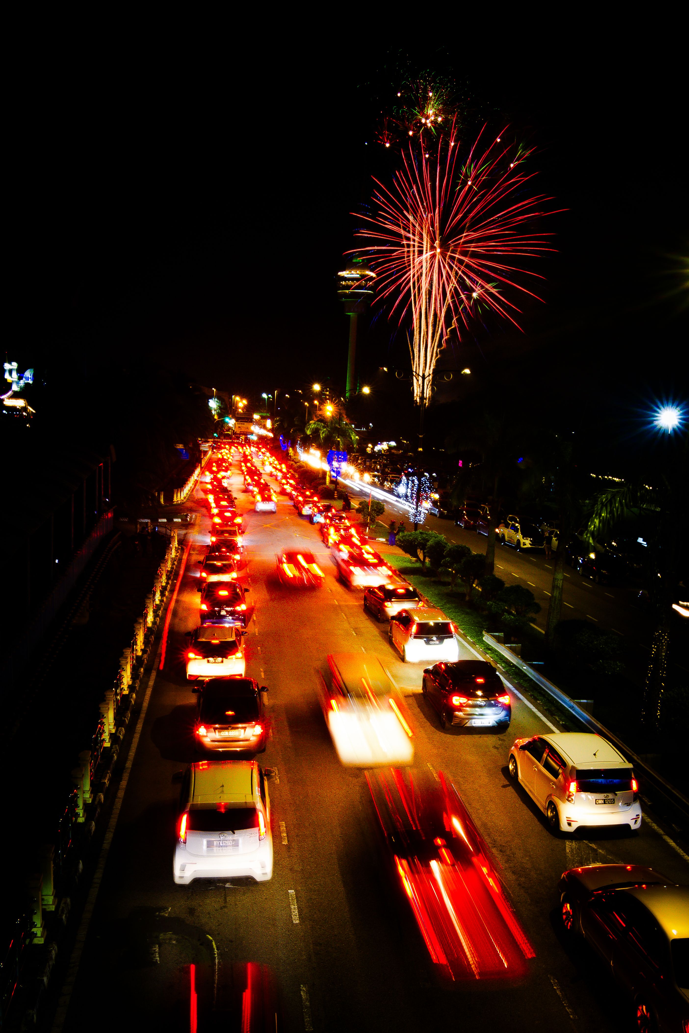 View of Cars on a Road and Fireworks against Dark Sky · Free Stock Photo