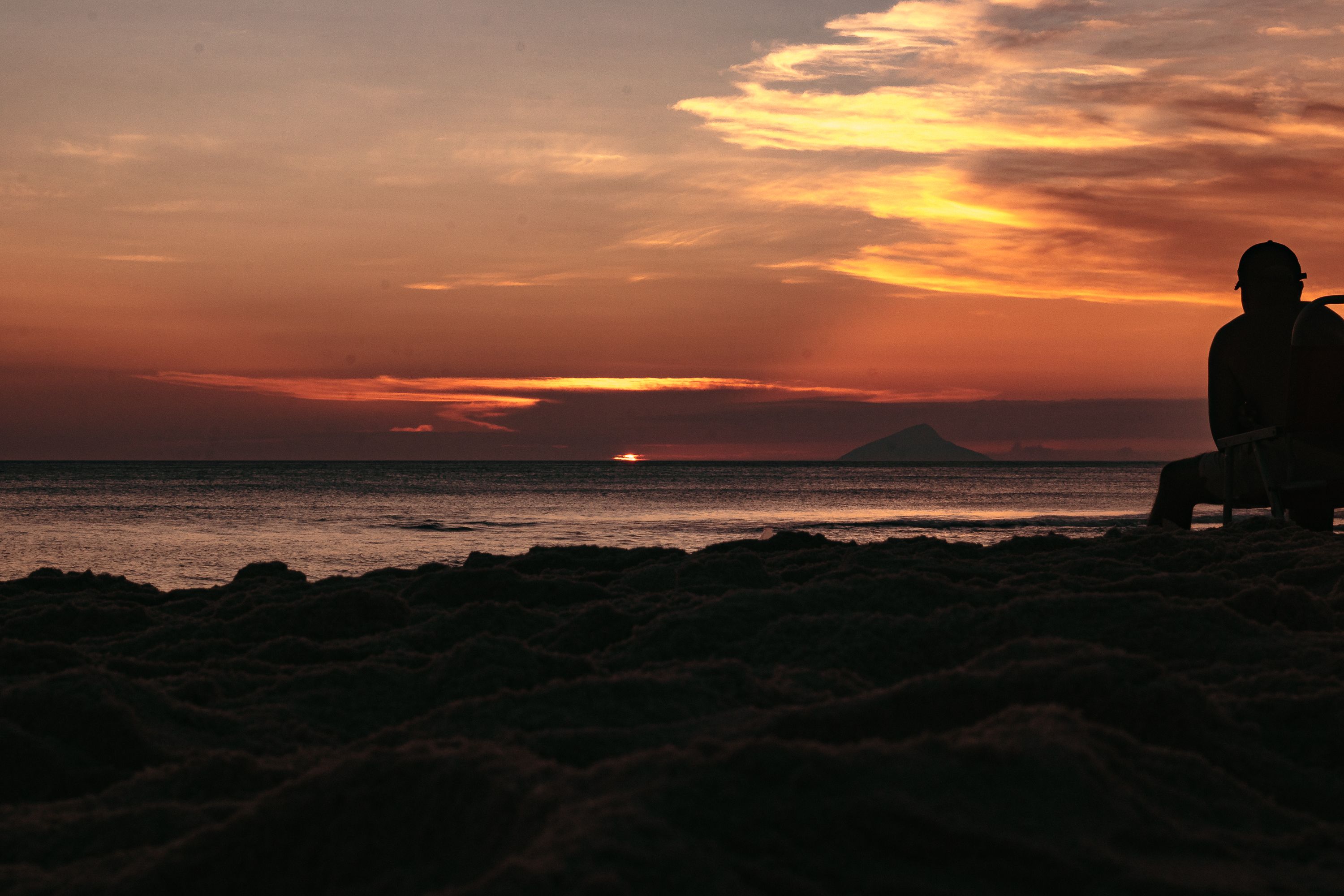 Person Sitting on Beach at Sunset · Free Stock Photo