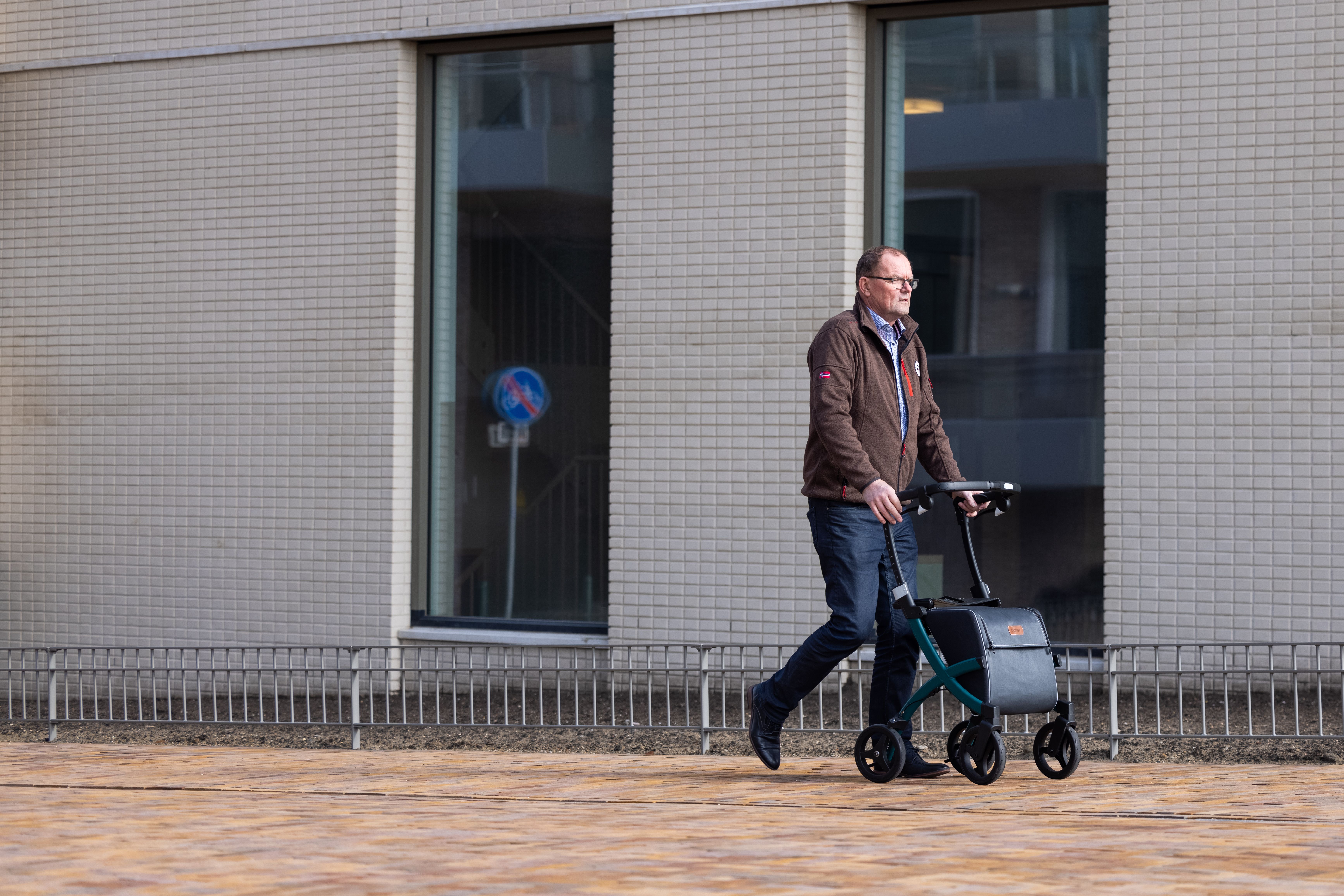 Elderly Man Walking on a Sidewalk with a Rollator with Attached ...