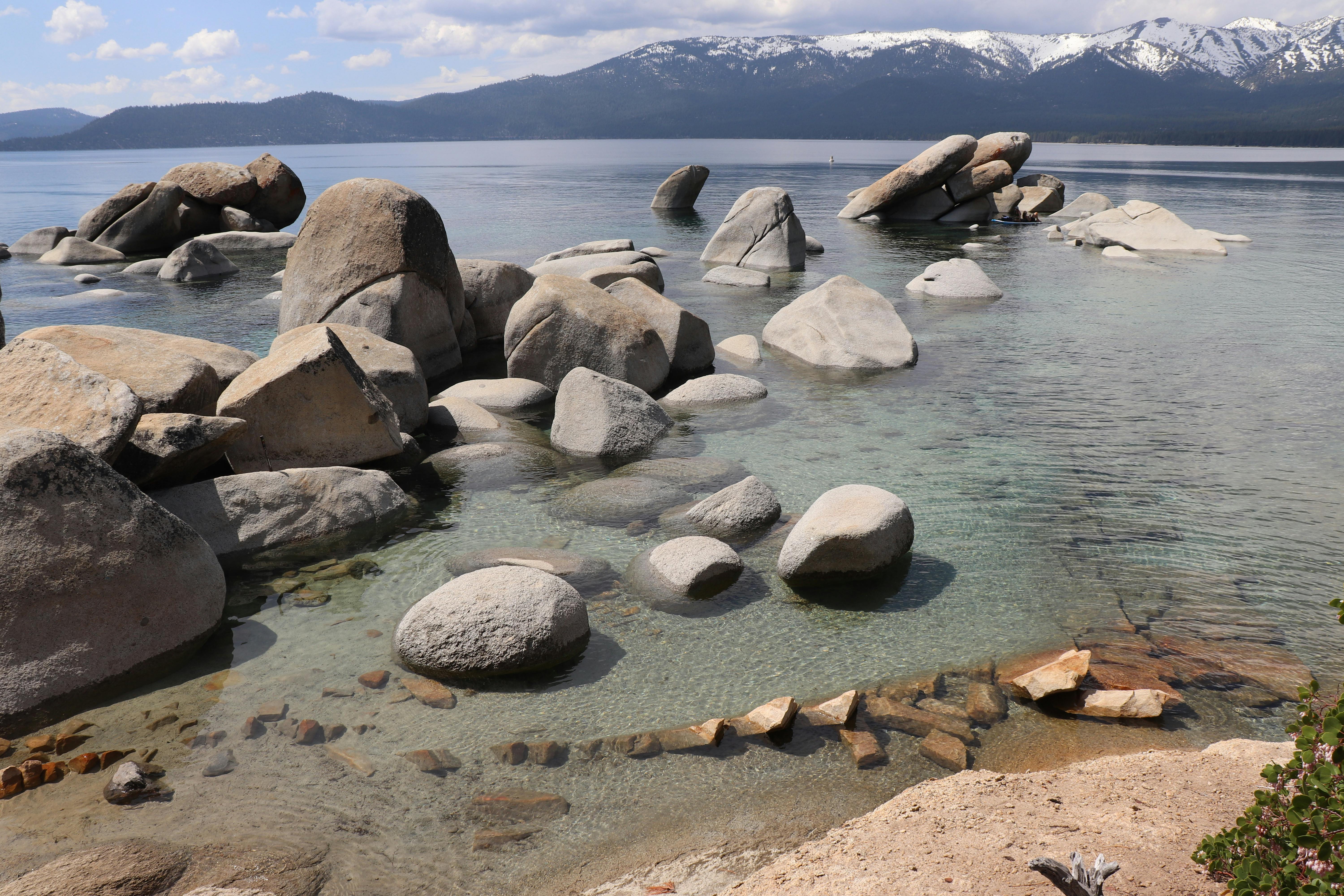 A rocky shore with water and boulders · Free Stock Photo