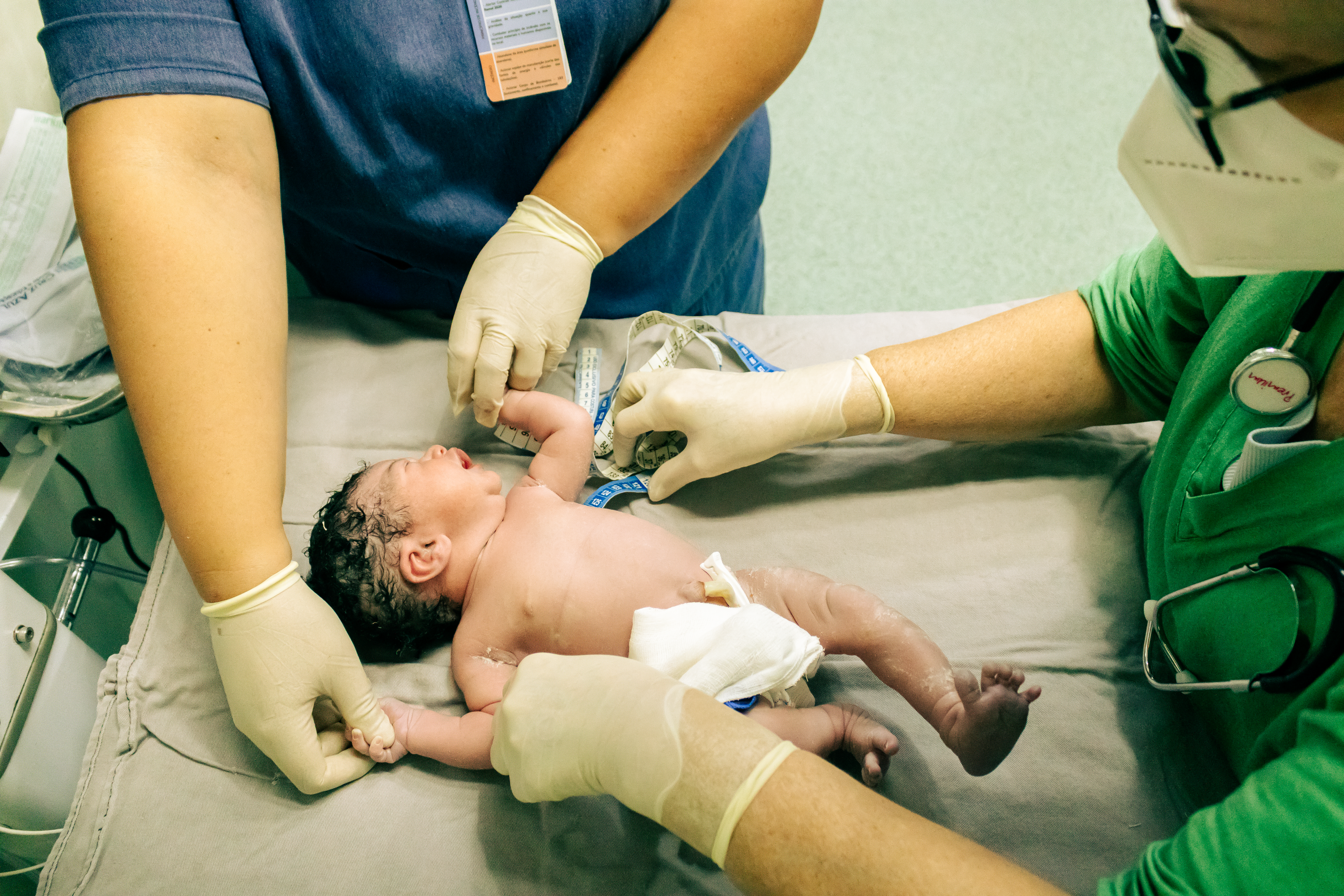 Newborn Baby Held by a Midwife Rubbing Eyes · Free Stock Photo