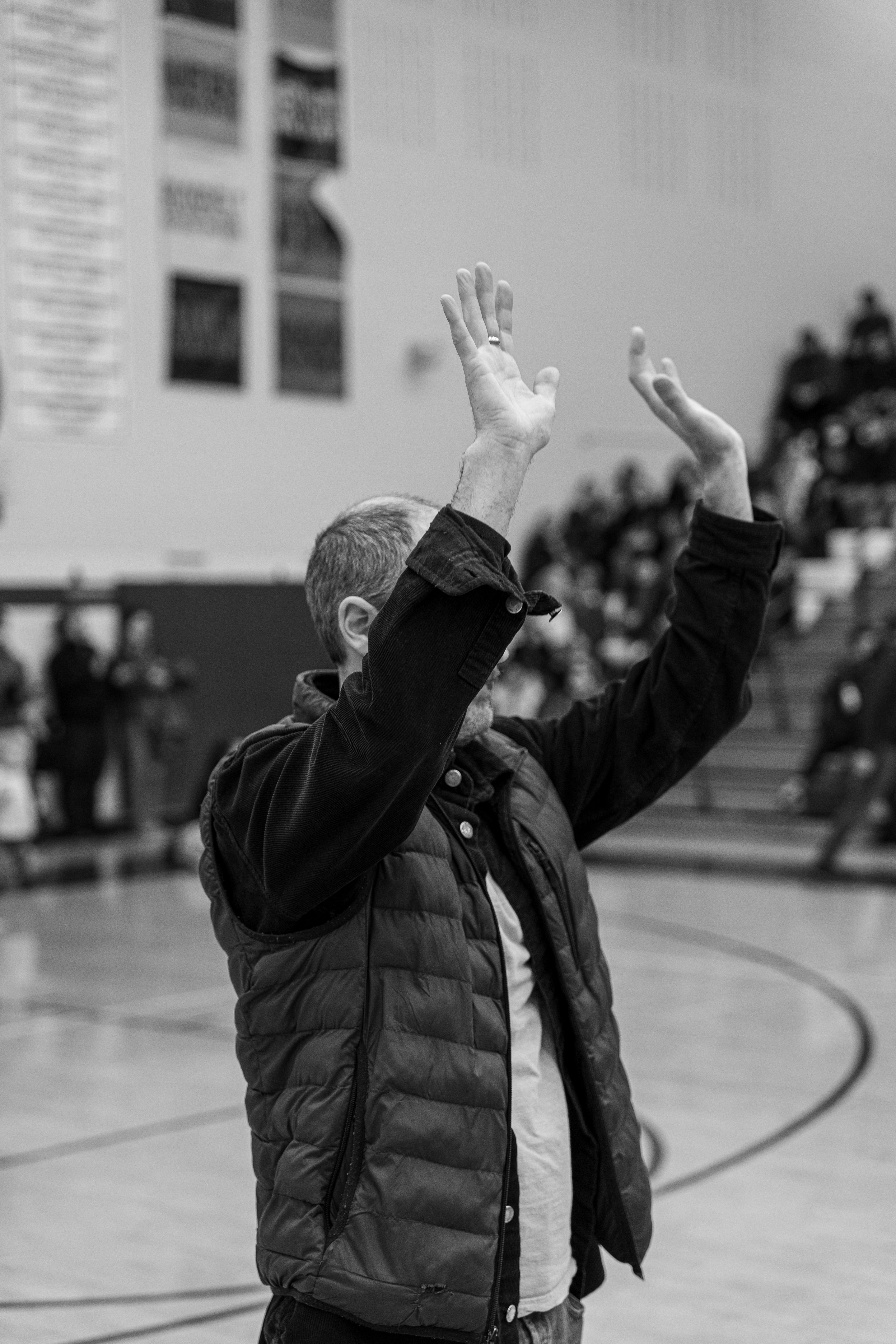 Man in Jacket Standing with Arms Raised at Event and Waving · Free ...