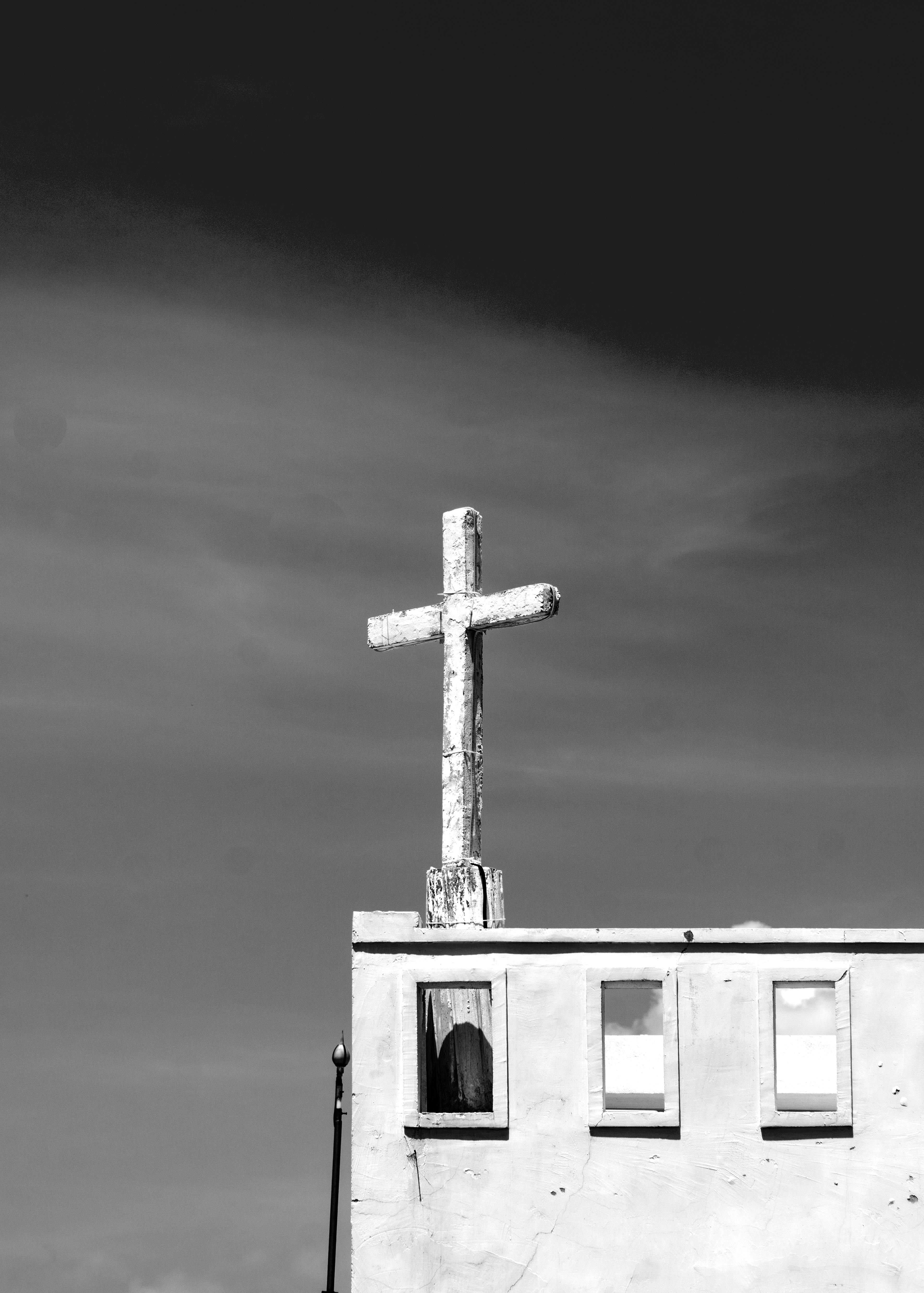 A cross on top of a building in black and white · Free Stock Photo