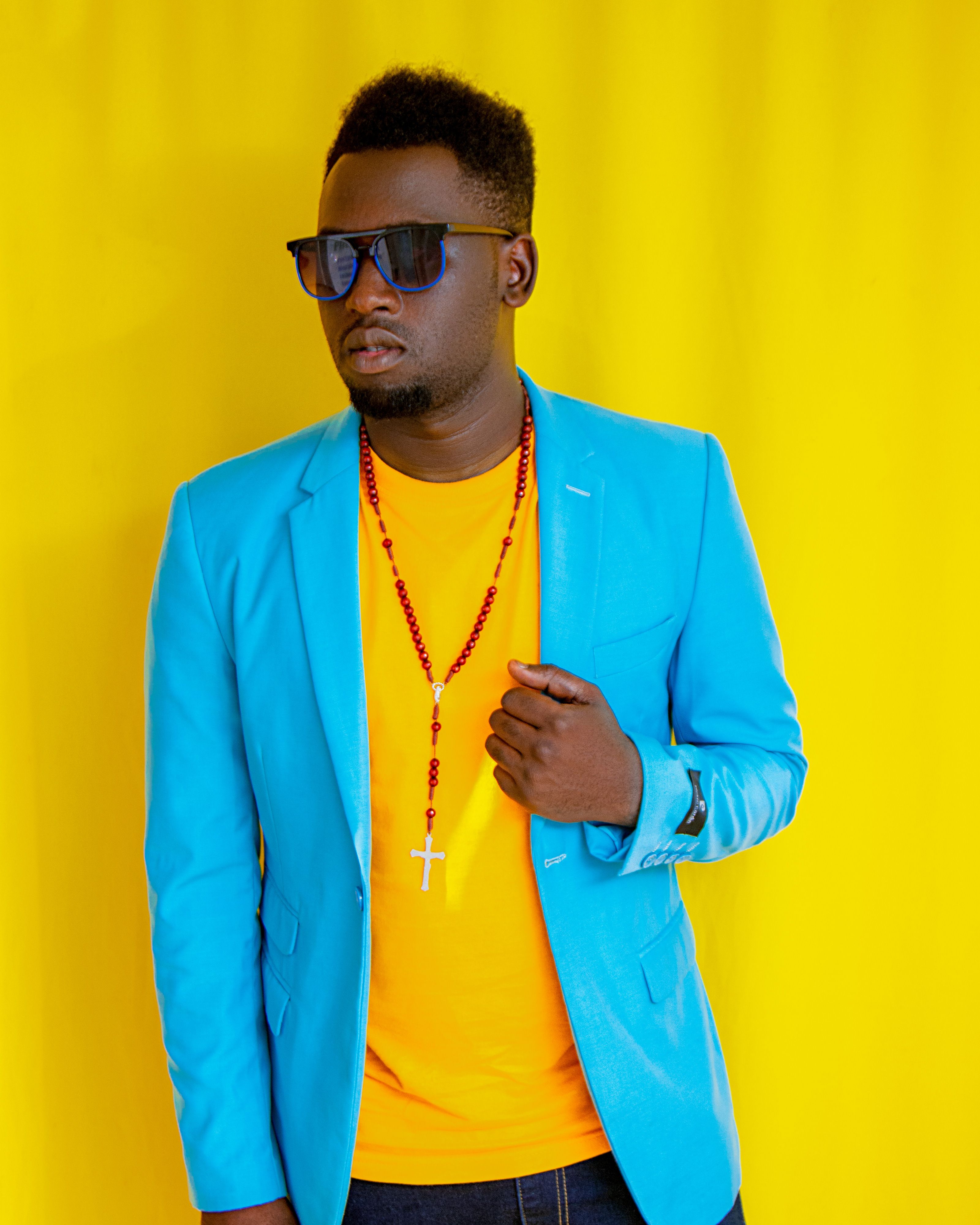 Man in Blue Jacket and Yellow Shirt Standing with a Yellow Background ...