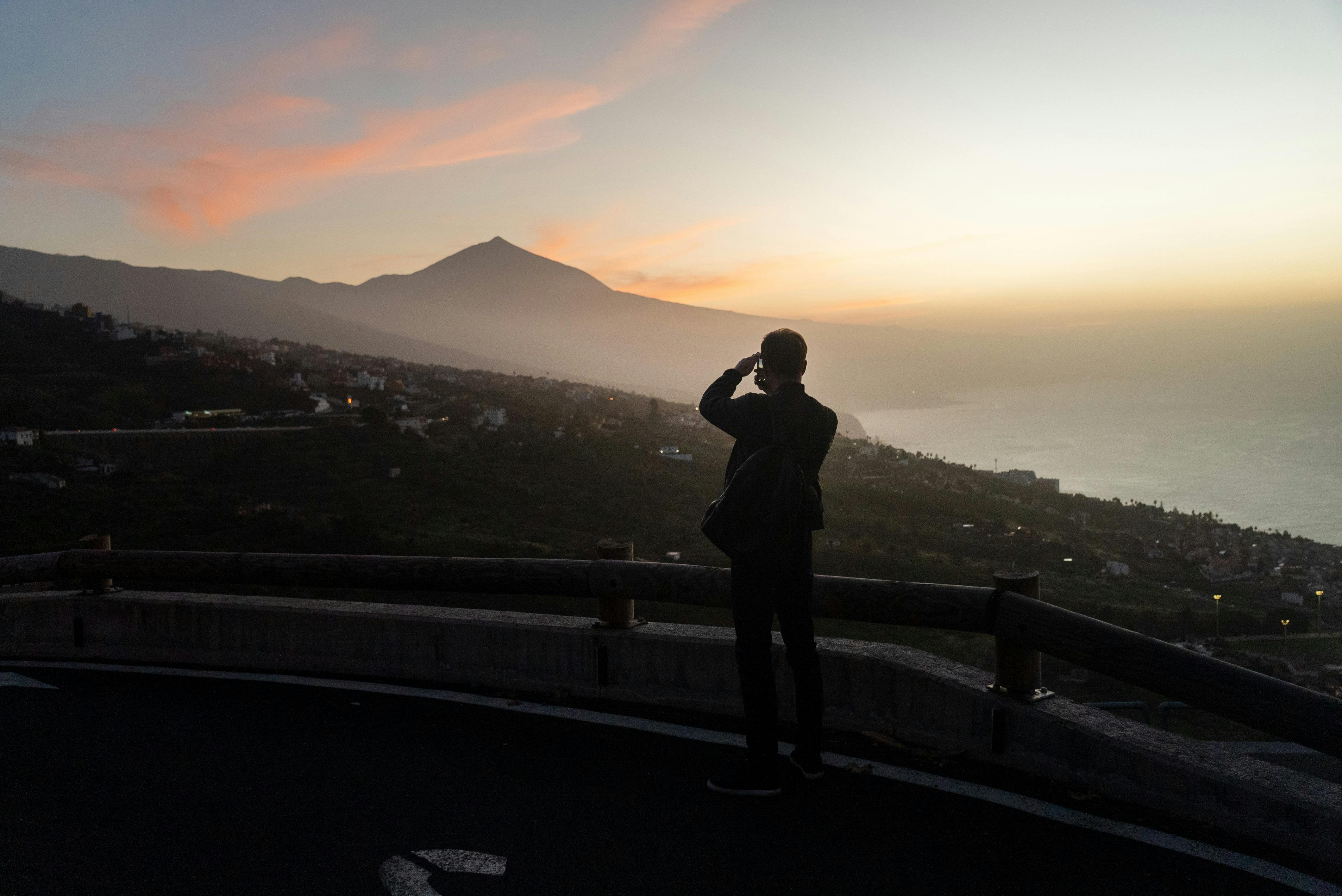 Man Standing Taking A Photo of Landscape with Mountain · Free Stock Photo