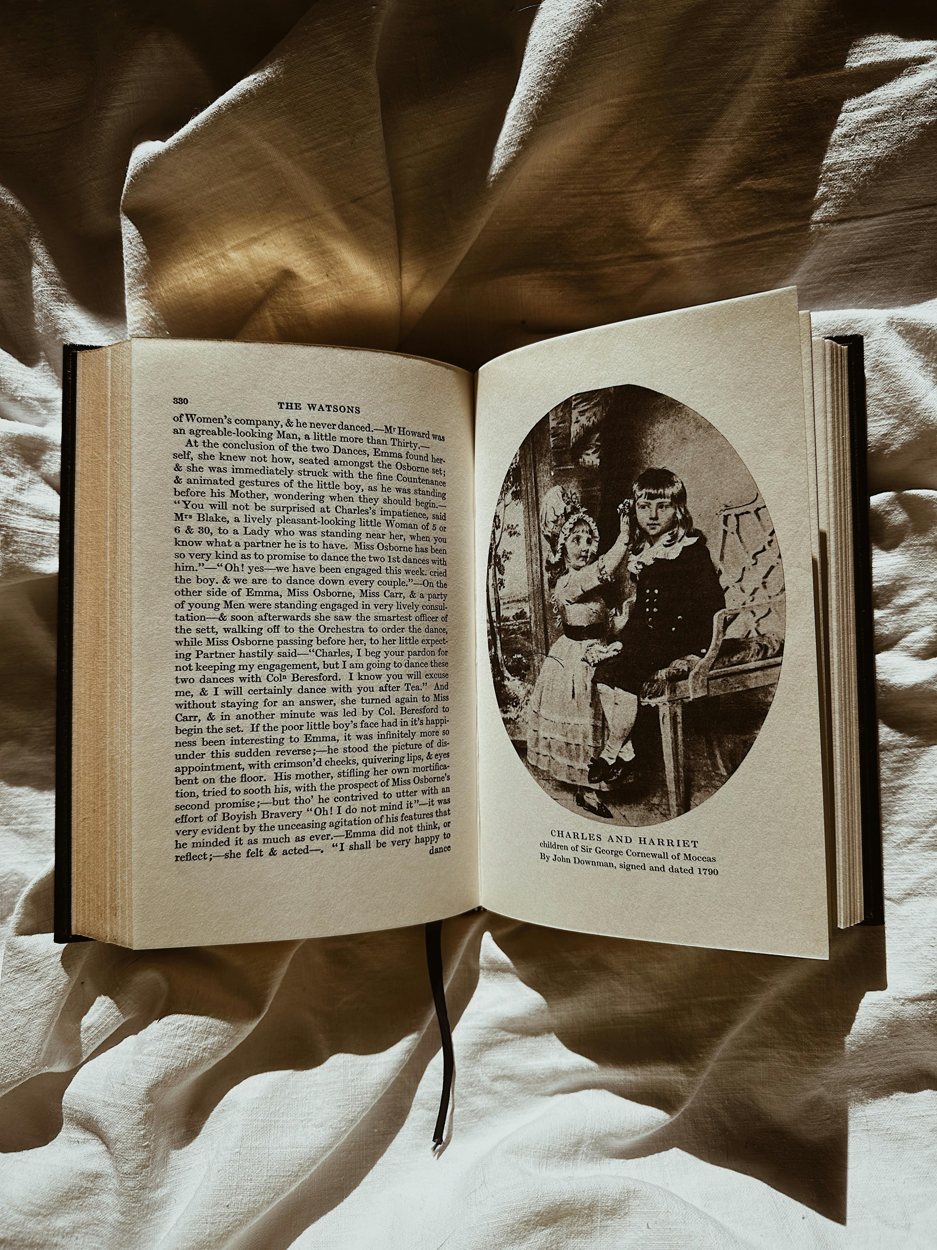 An Open Book Lying on Bed Sheets · Free Stock Photo