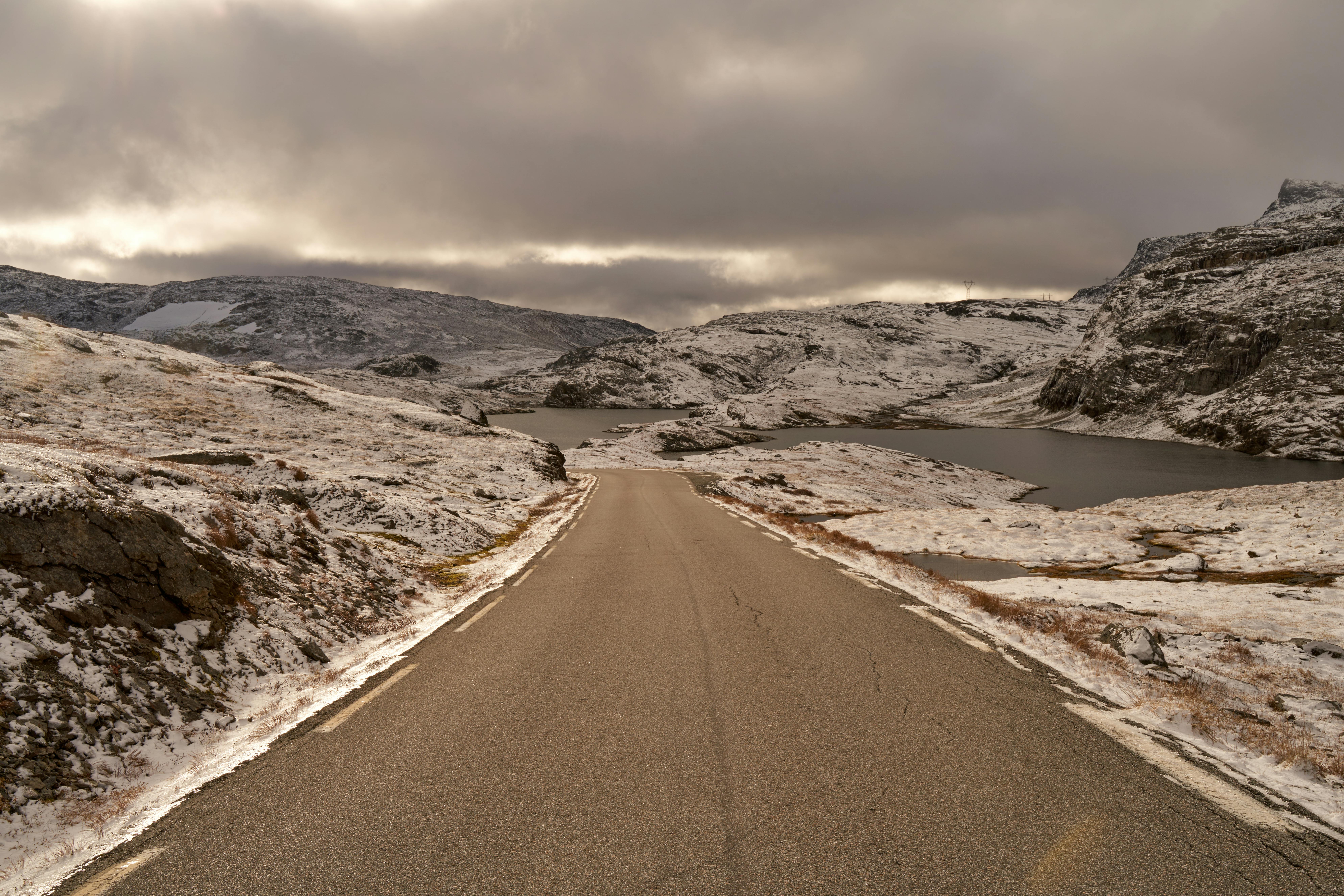 Concrete Road Near Body Of Water · Free Stock Photo