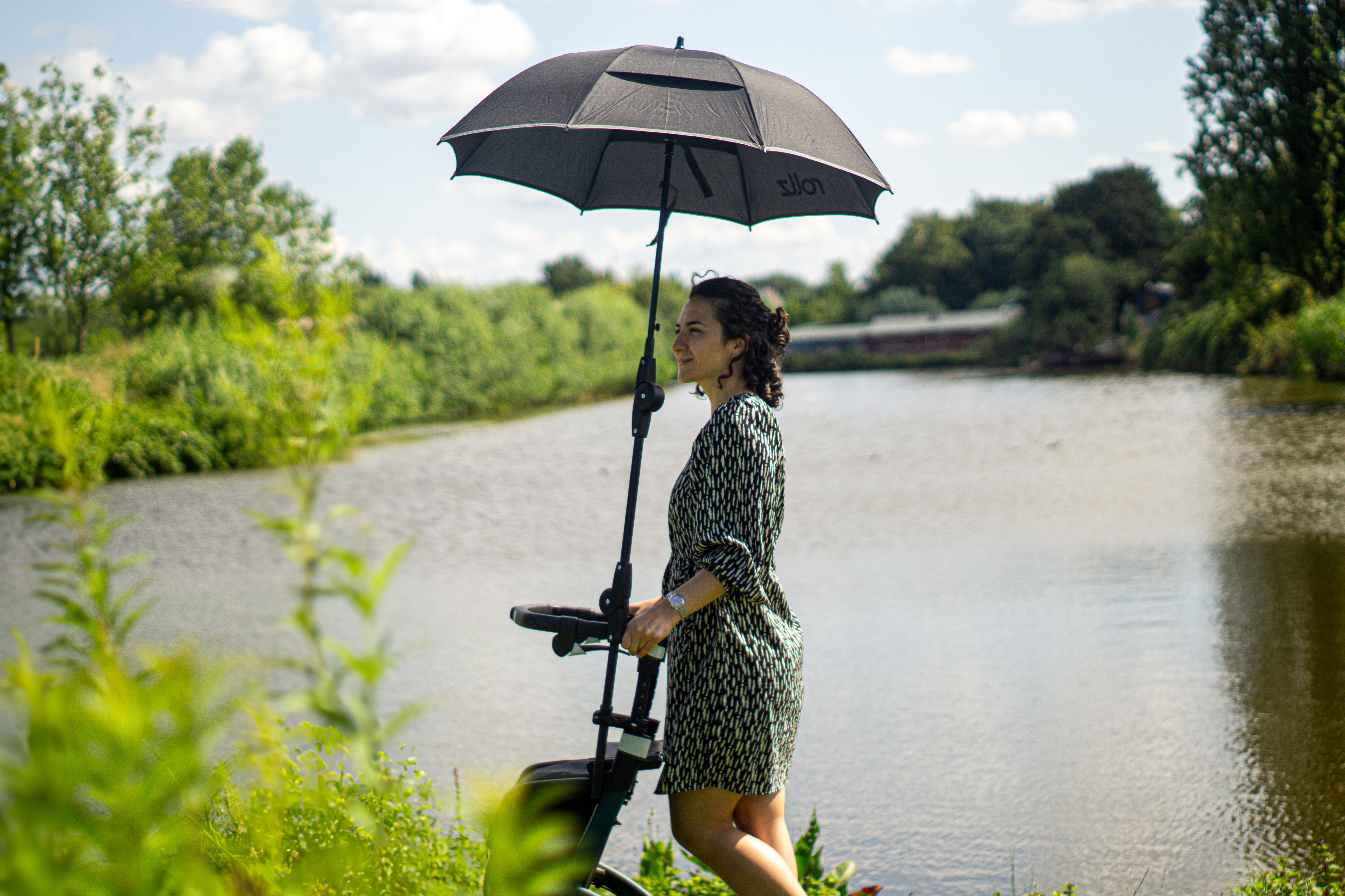 Woman walking next to a lake with a rollator walker · Free Stock Photo