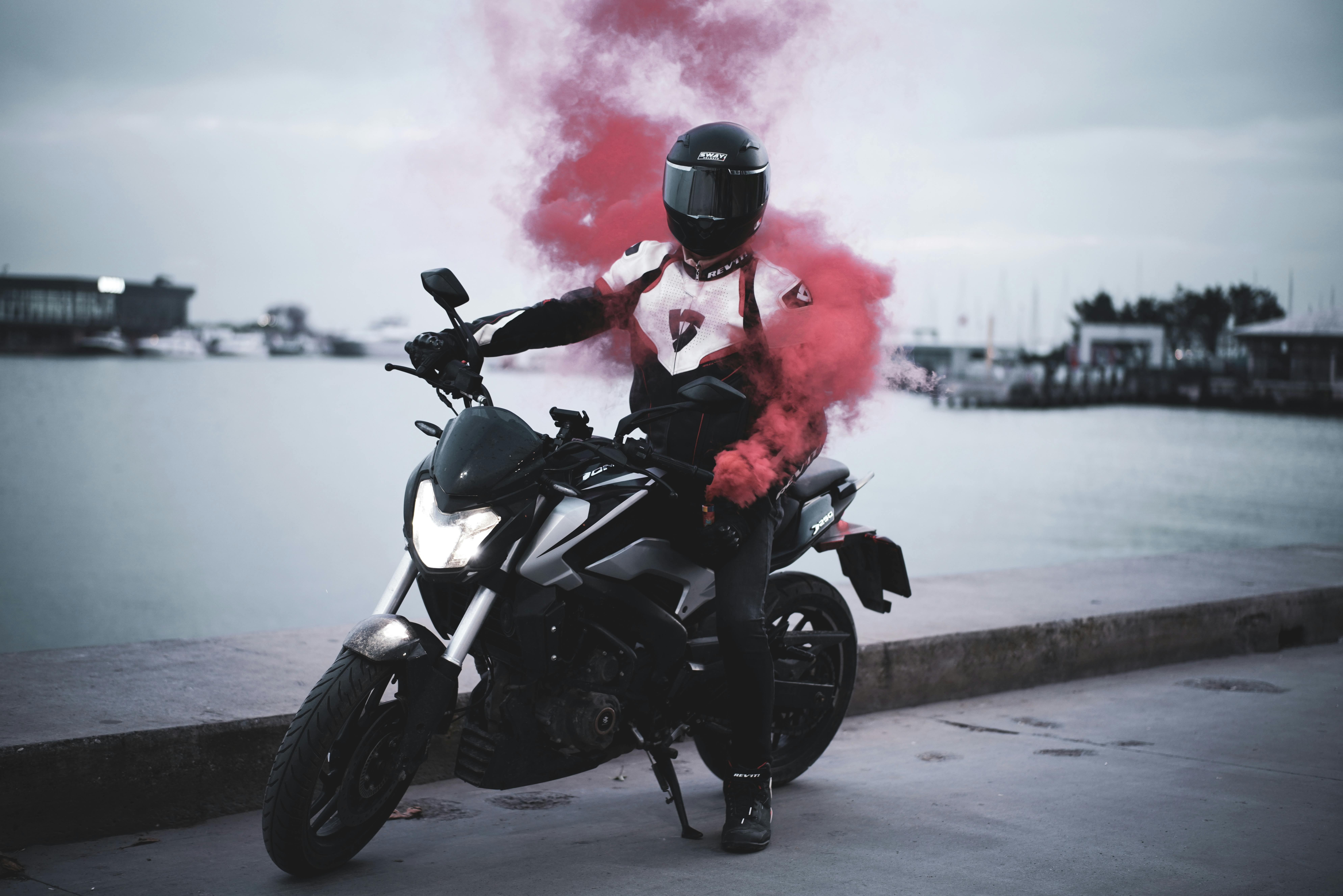 A man on a motorcycle with red smoke coming out of his helmet · Free ...