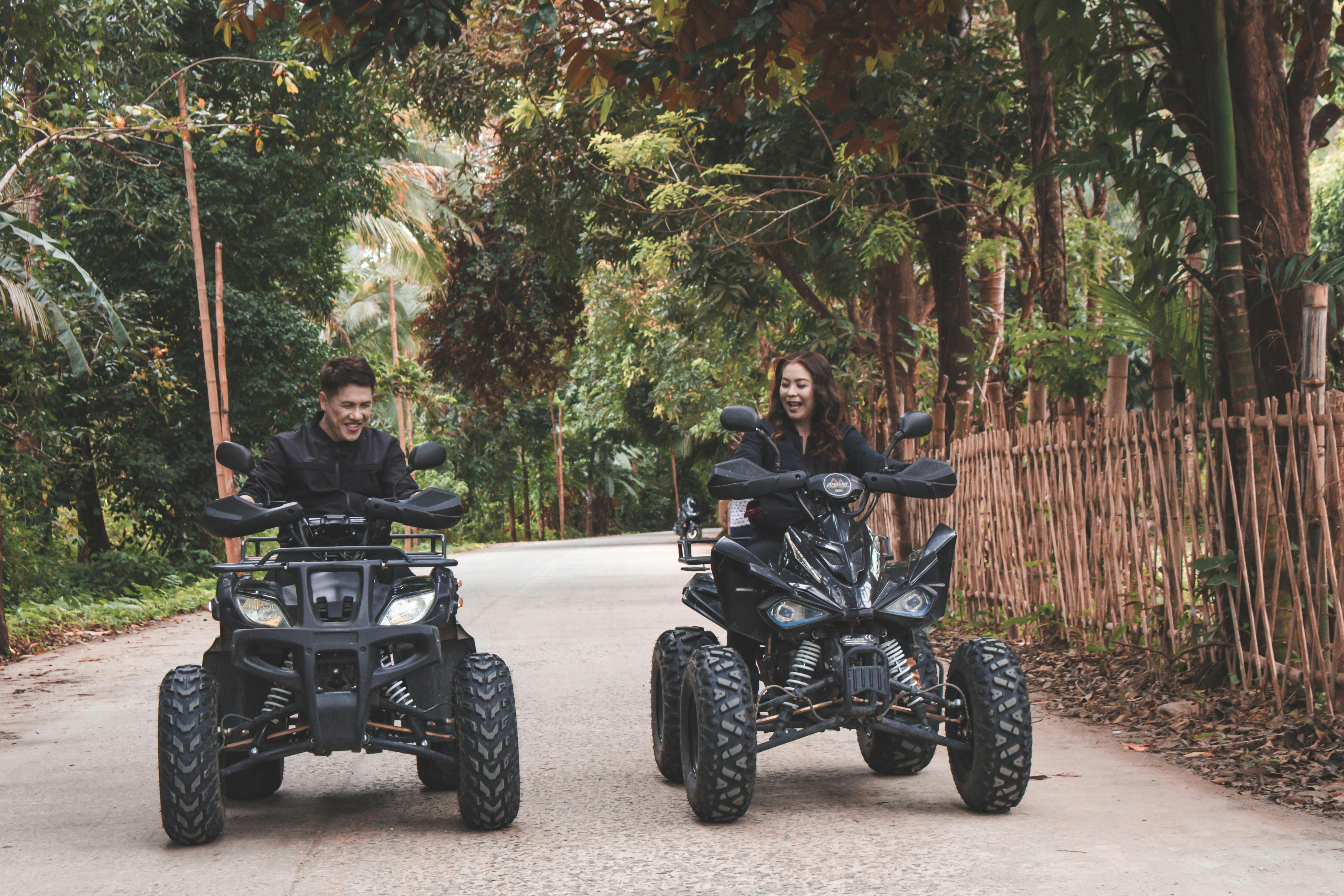 Two people riding atvs on a road · Free Stock Photo
