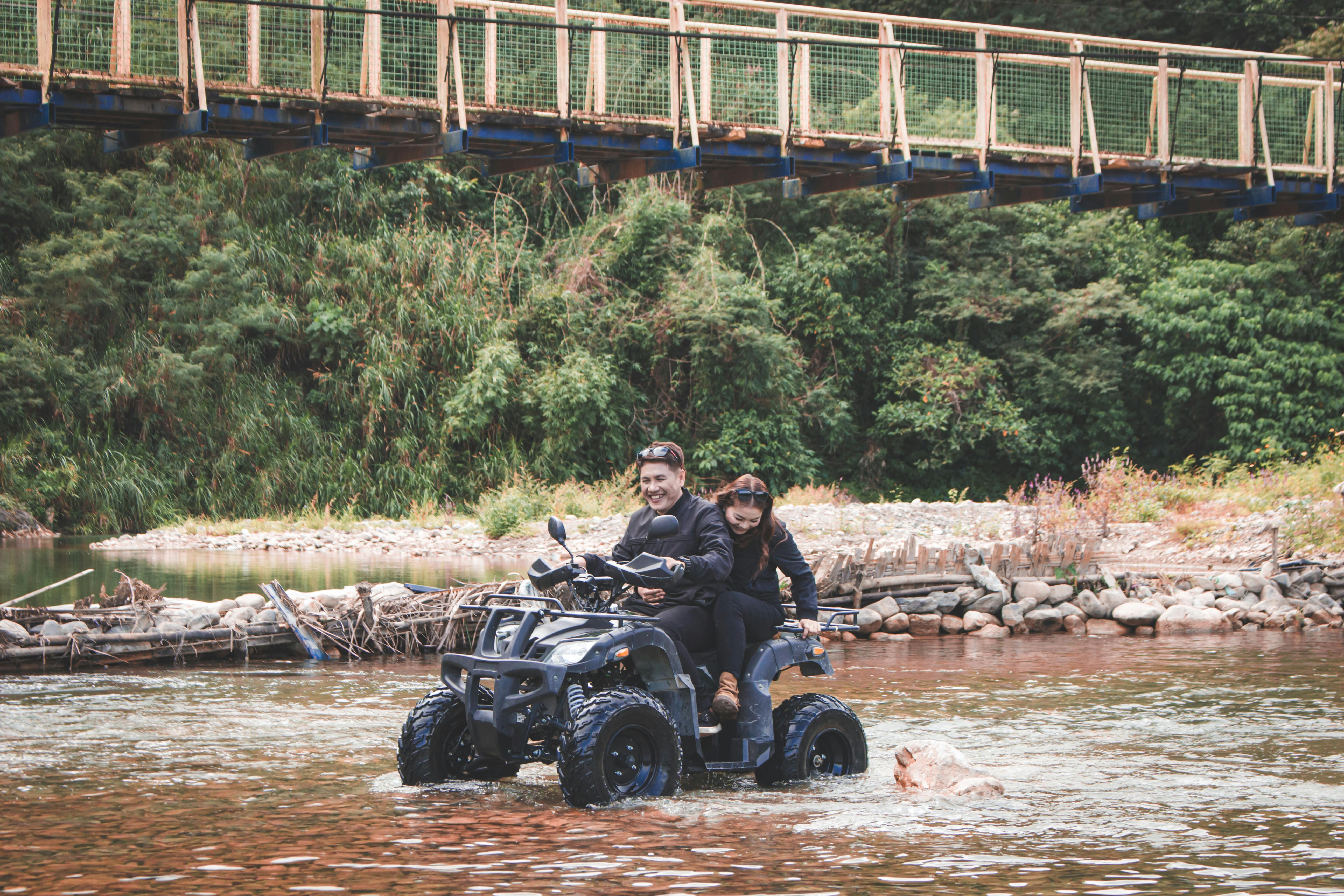 Couple Crossing the River on the Quad Bike · Free Stock Photo