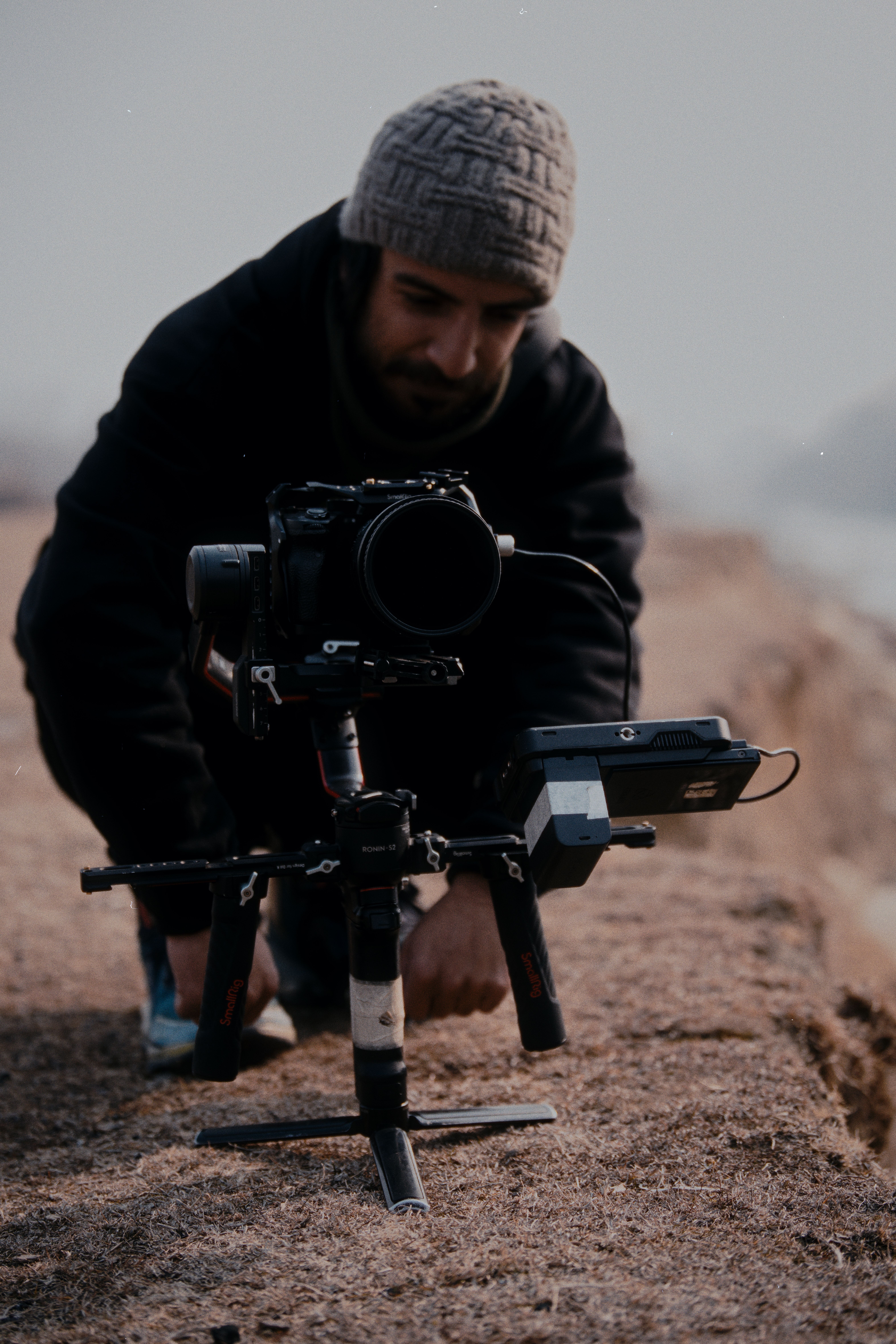 Photographer Wearing a Hat, Squatting with a Camera on a Tripod · Free ...