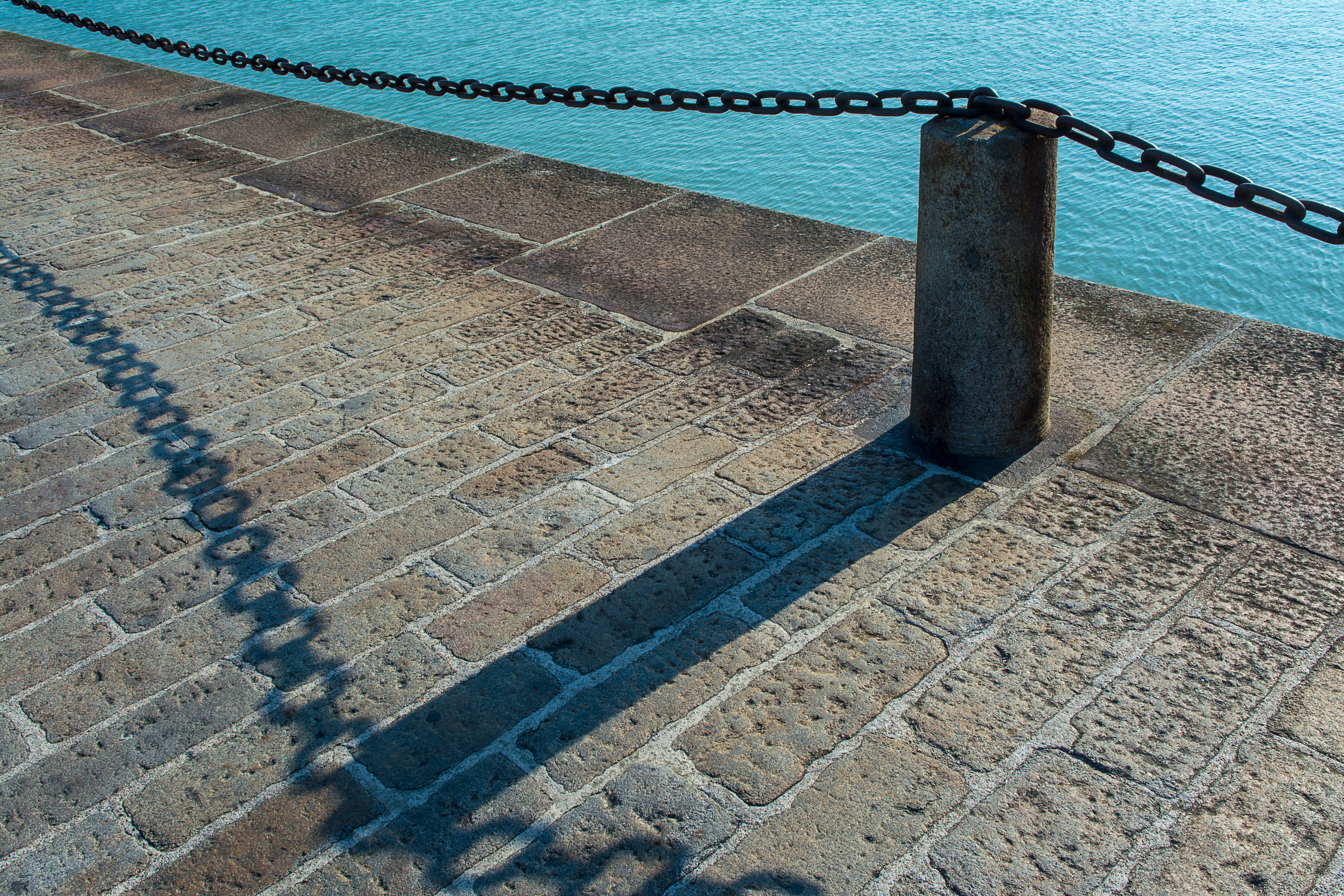 A chain is attached to a post near the water · Free Stock Photo