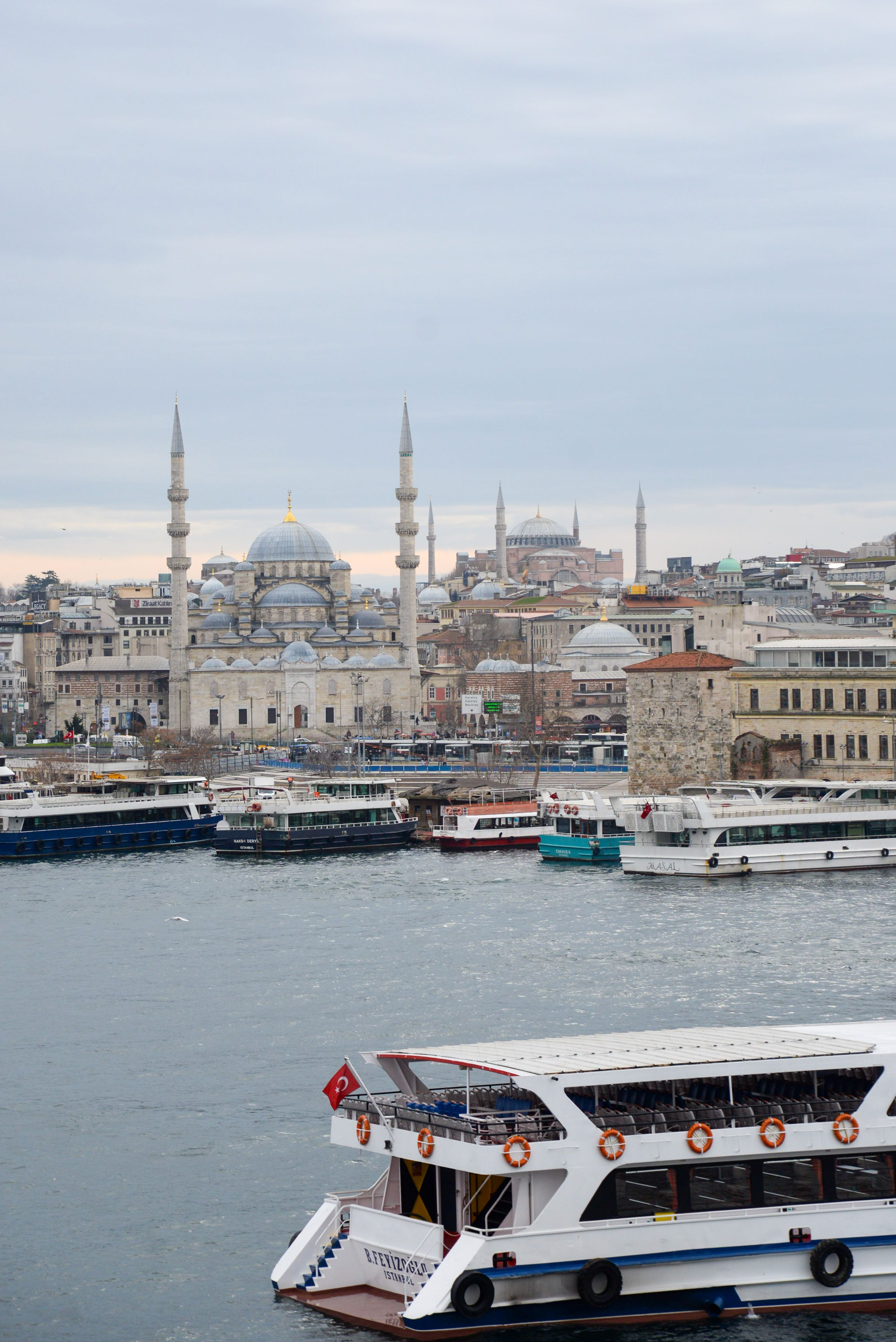 A boat is docked in front of a large mosque · Free Stock Photo